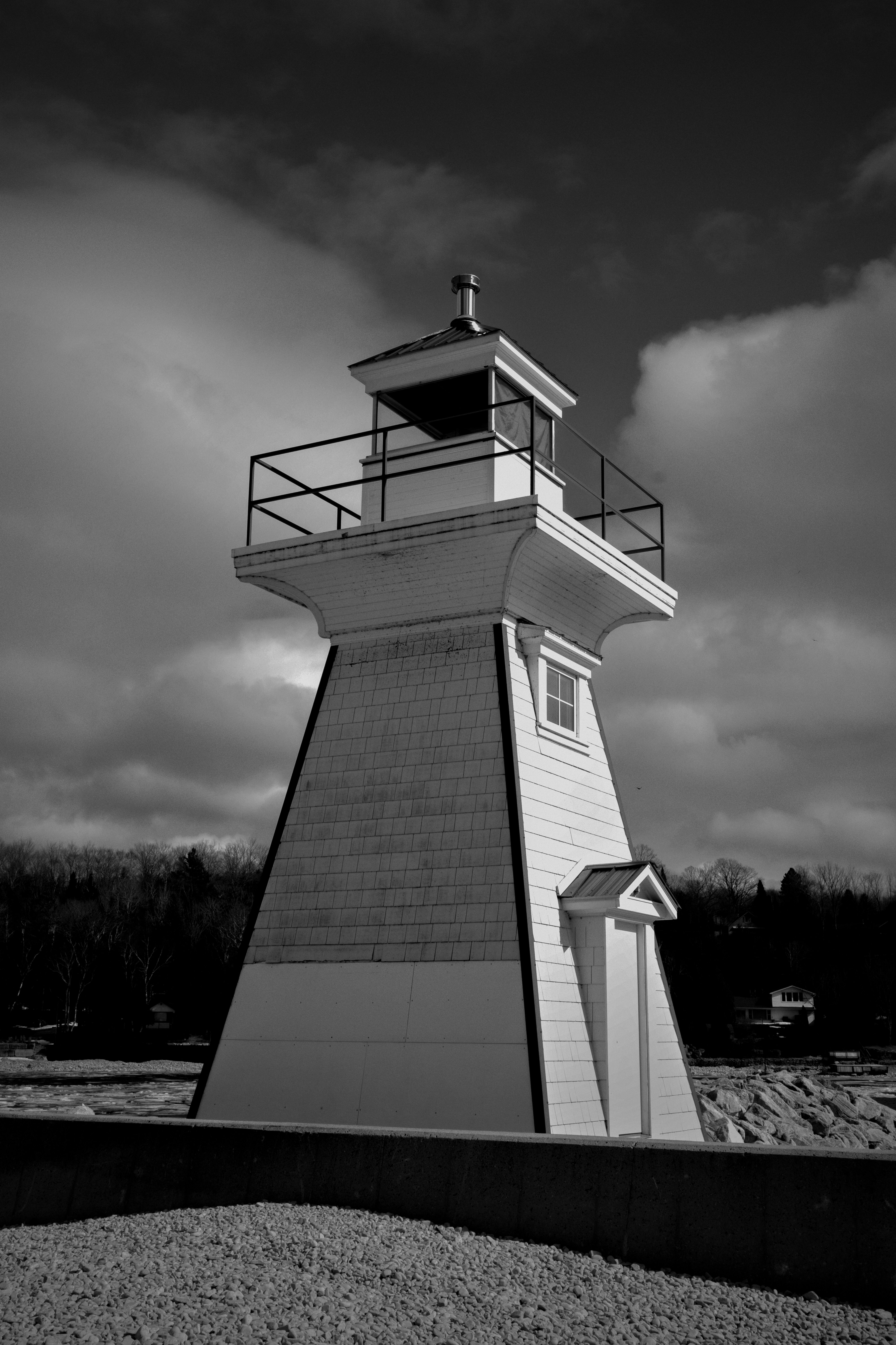 Static Sentinel: A weathered lighthouse standing against the clouded sky