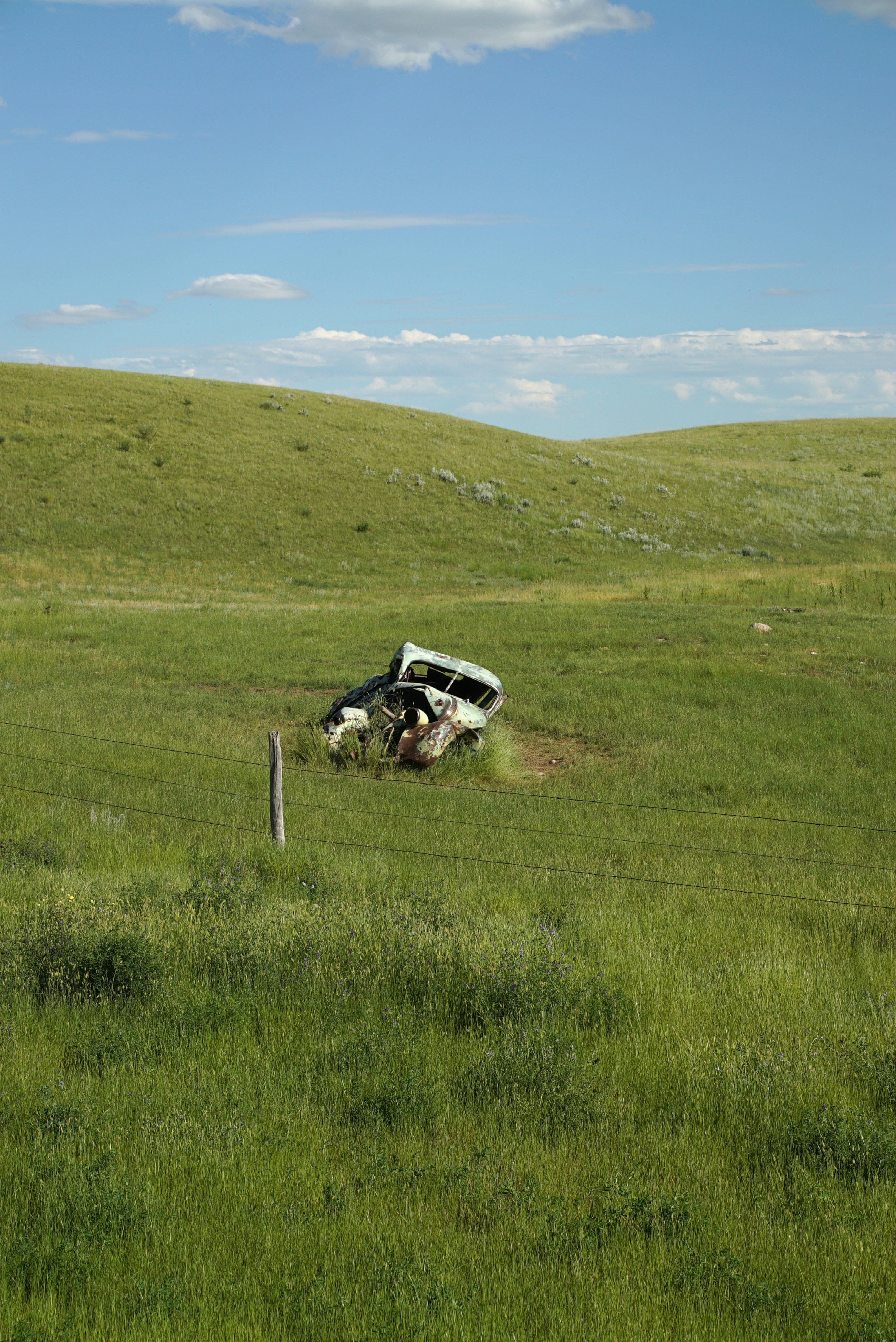 Abandoned Car in a Green Distant Hillscape