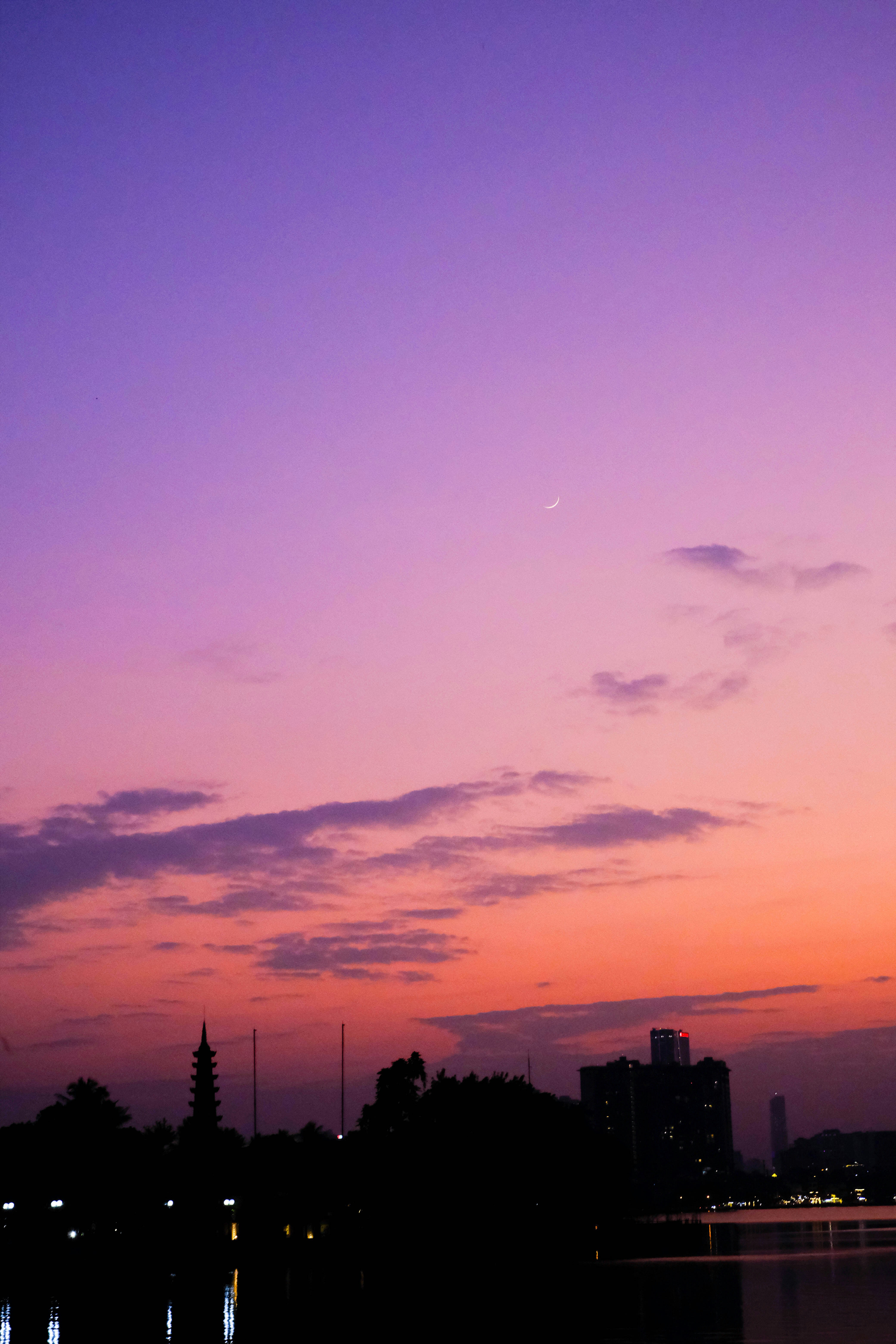 Twilight Skyline: Crescent Moon over a Quiet Harbour