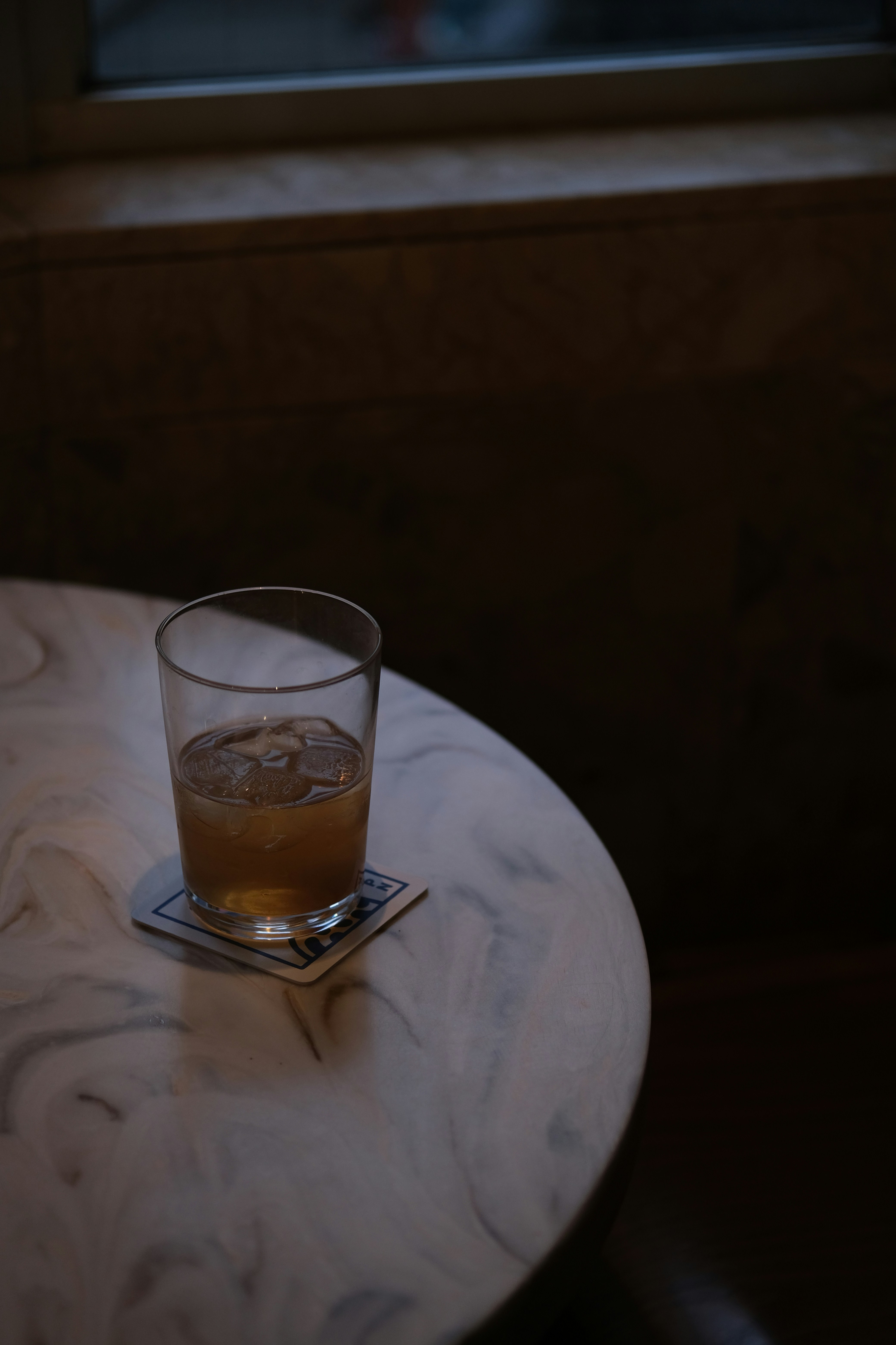 Amber Glass on Marble Table: Quiet Afternoon in a Dim Room