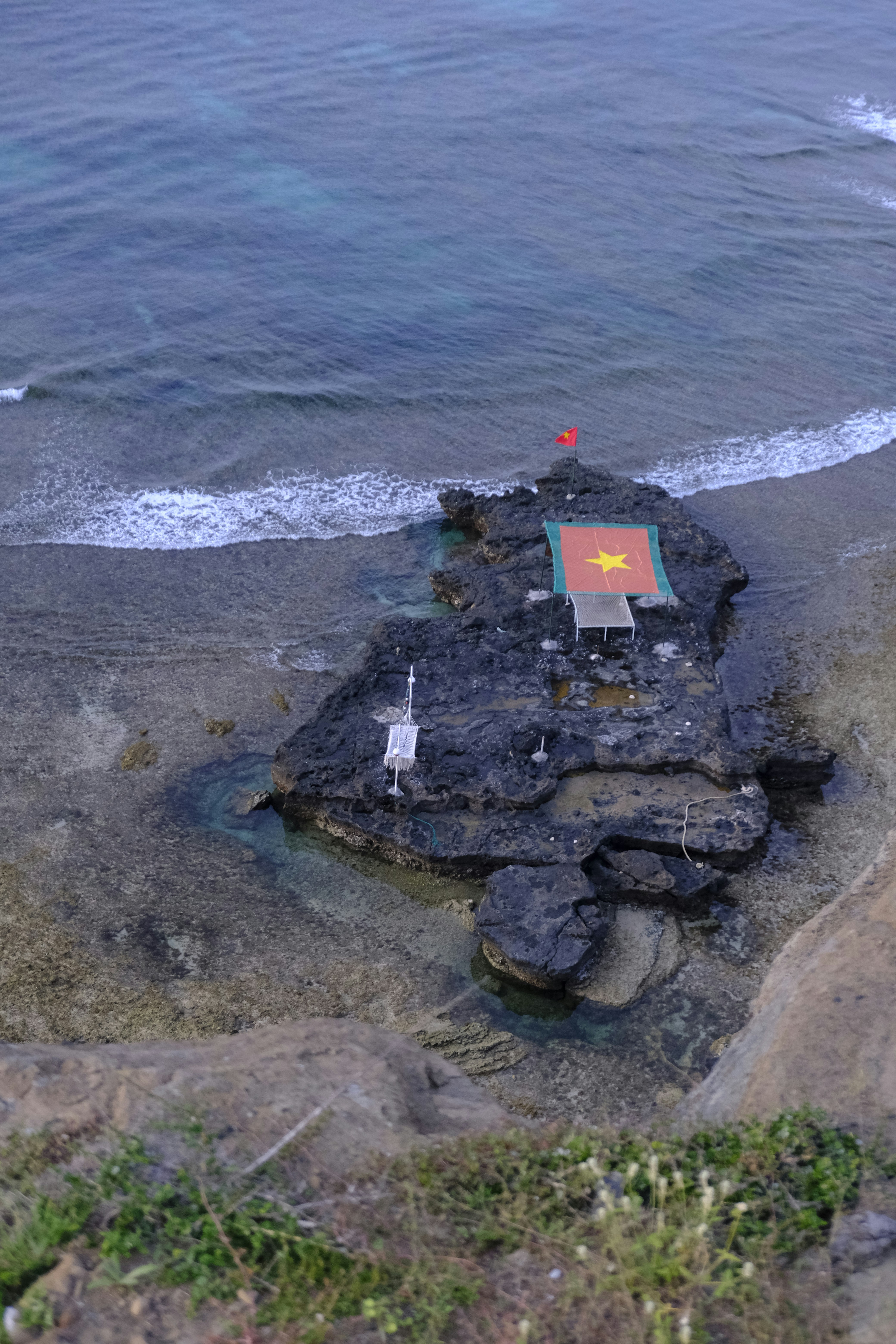 Rocky outcrop with a star-marked canopy overlooking the sea