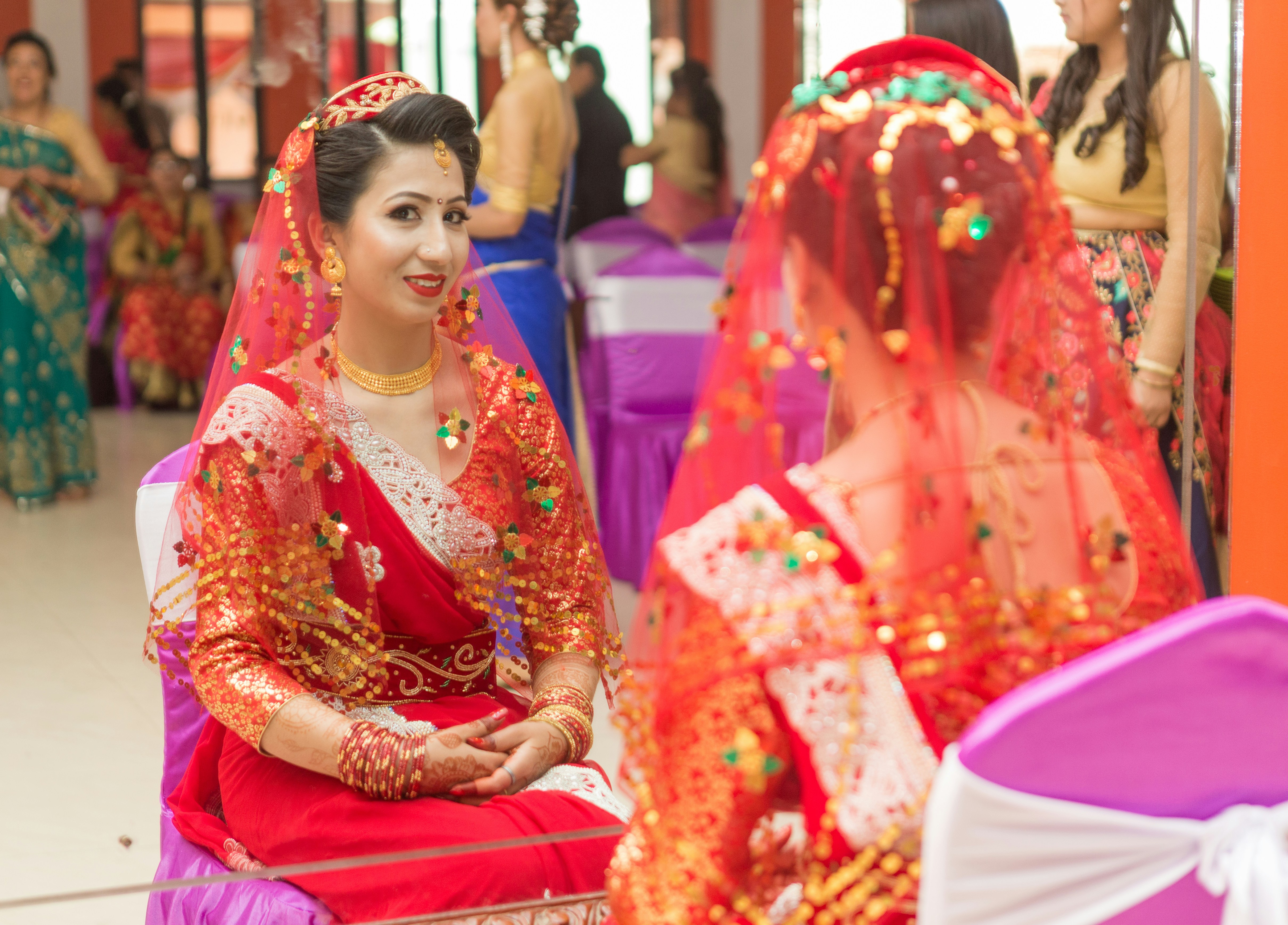 Red-sari Bride in Quiet Reflection at a Multicolored Indian Celebration
