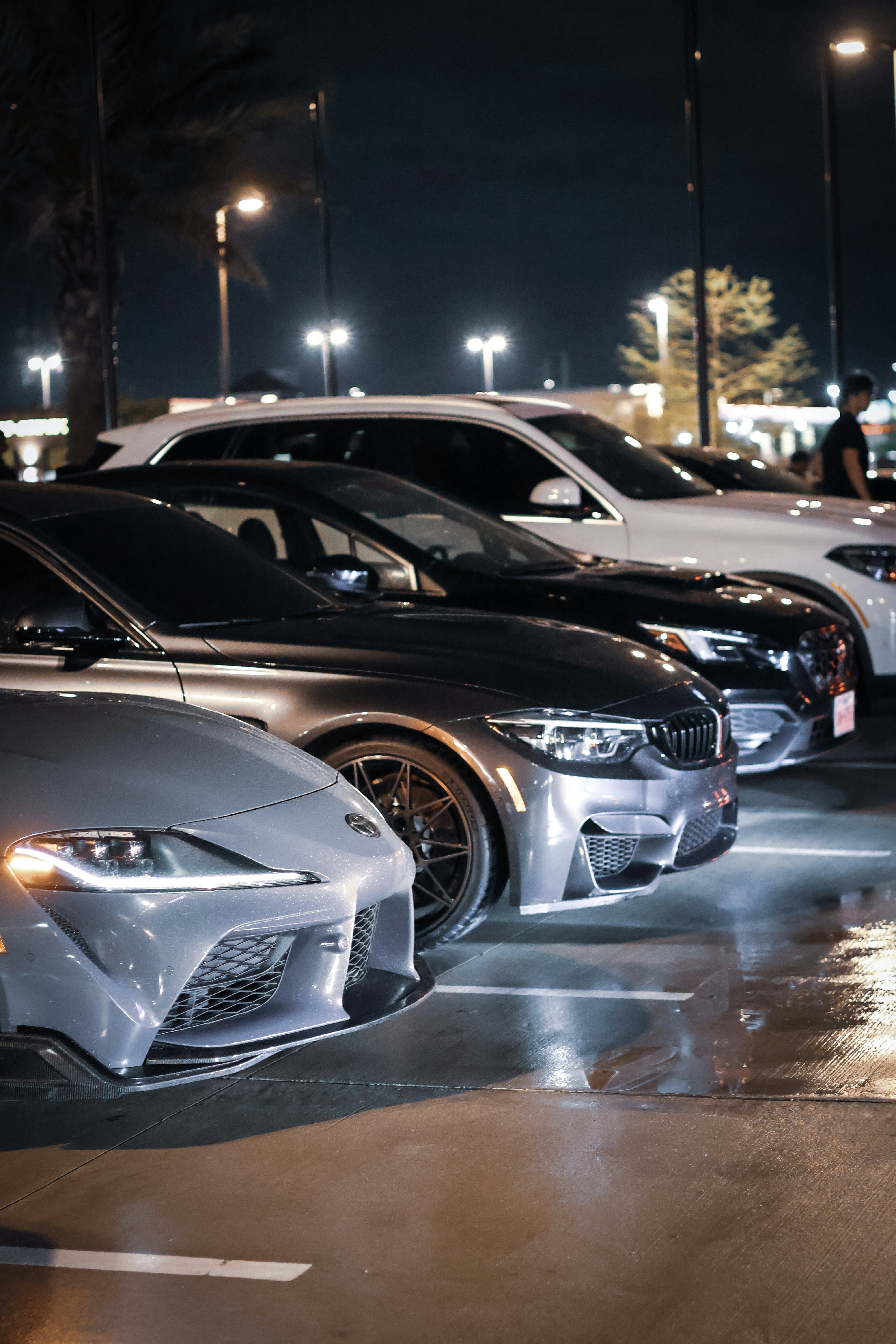 Night Row: Glossy Car Lineup Under Parking-Lot Lights