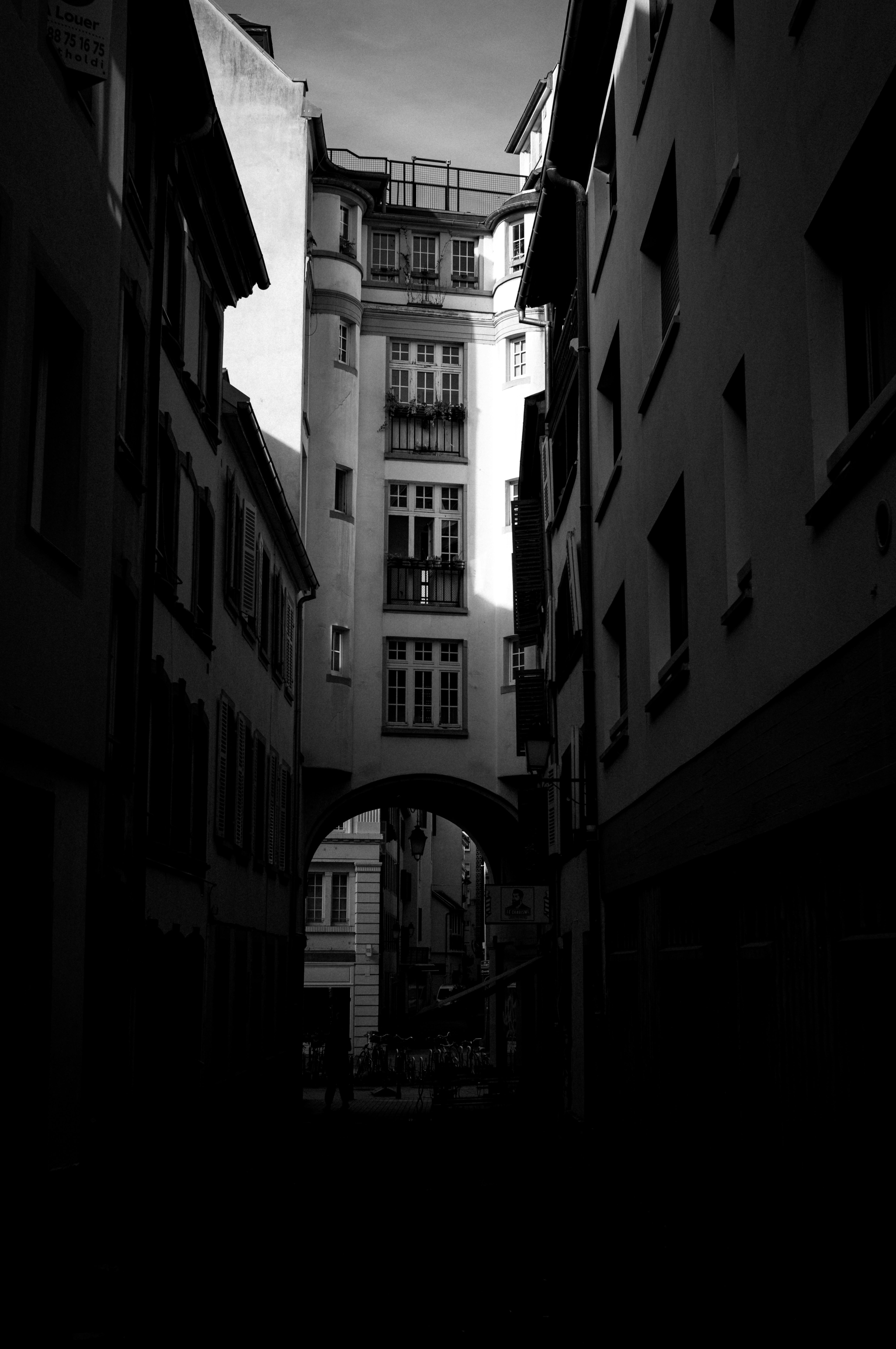 Moonlit Archway: A Narrow European Passage Illuminated by Sky