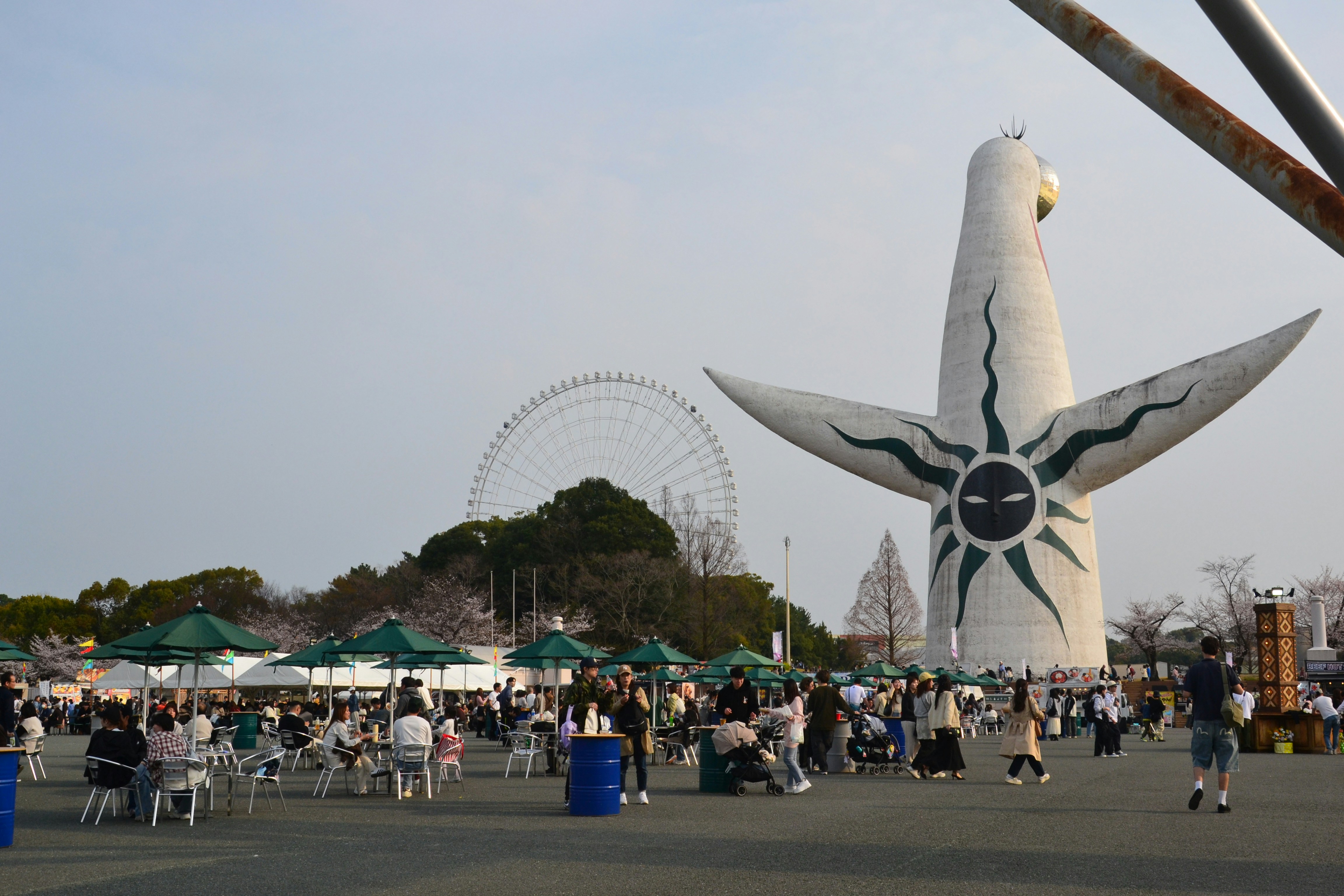 Marina Park Spectacle: A Large Statue and Ferris Wheel overlooking a sunlit plaza