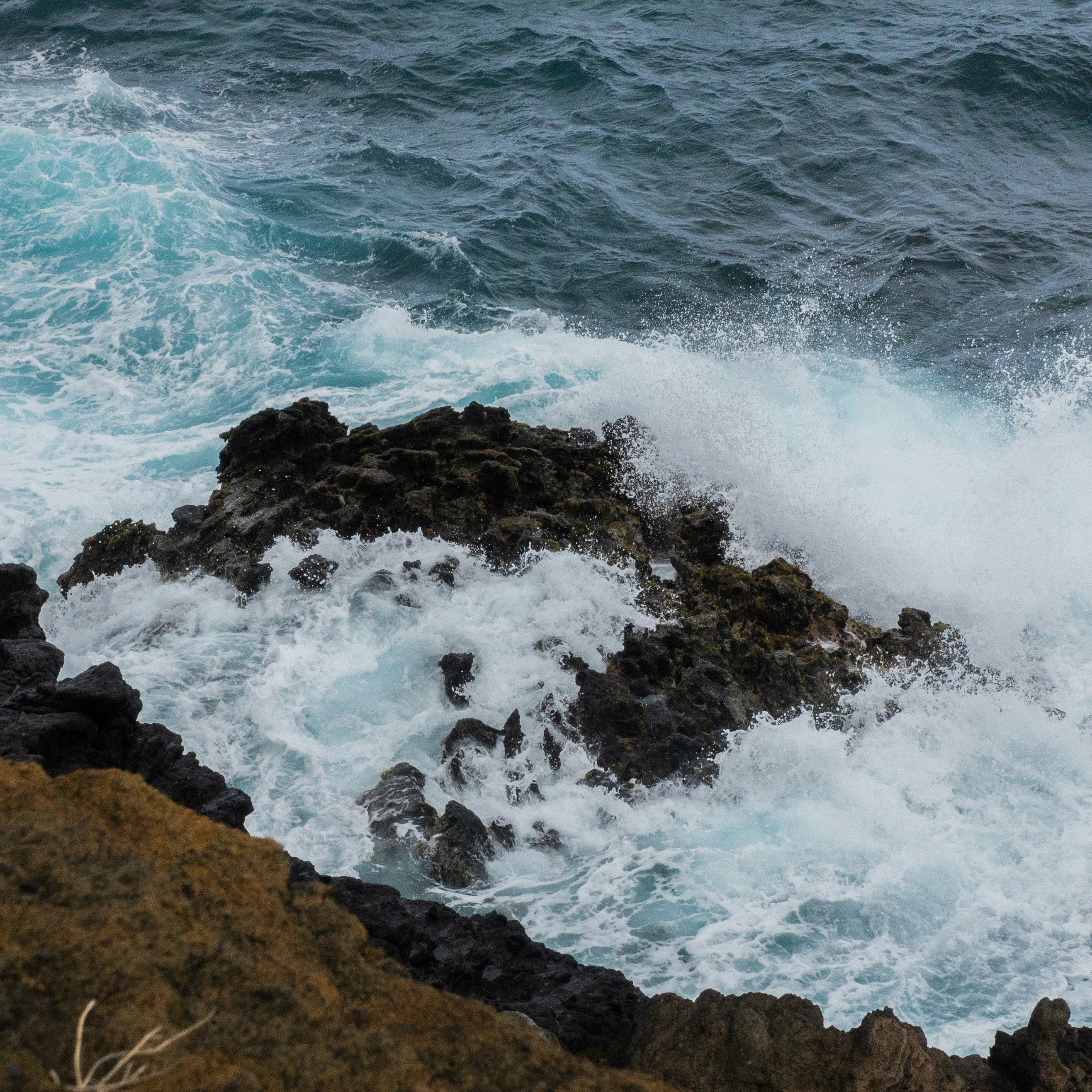 Rugged Break: Waves Clashing Against Coastal Boulders