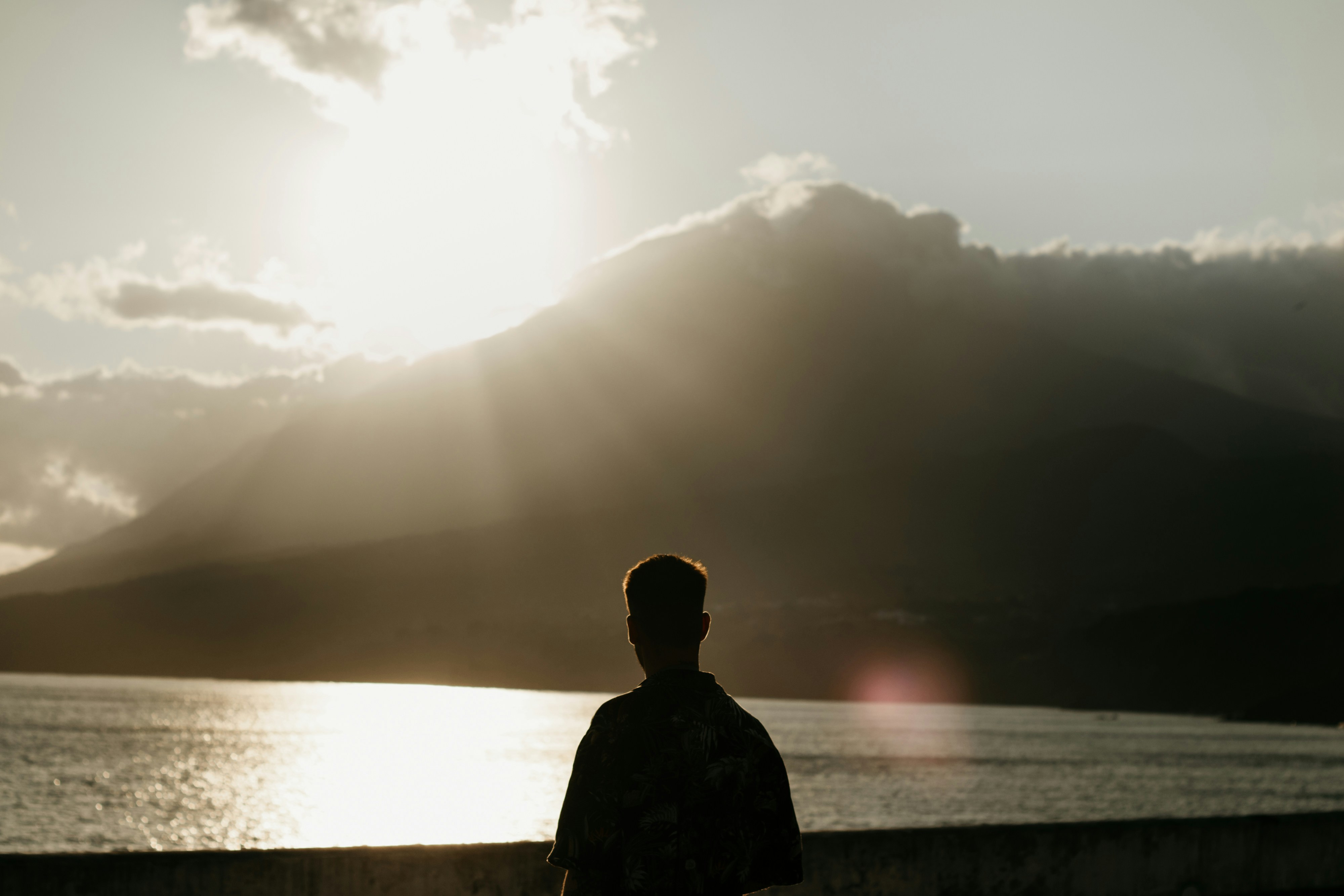 Silhouette at Dusk: A Lone Observer Before the Volcanic Horizon
