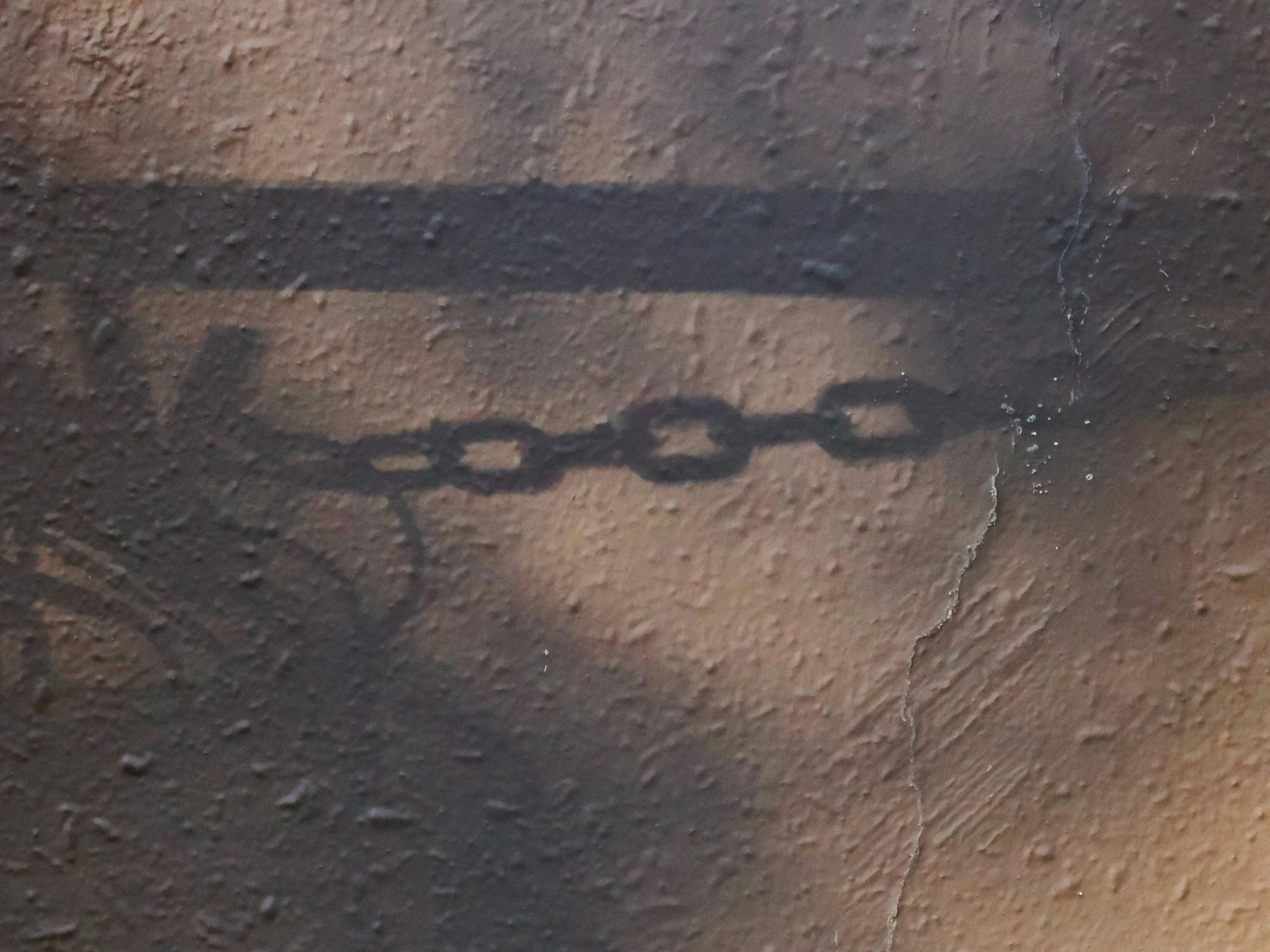 Shadow of a Chain on Weathered Concrete