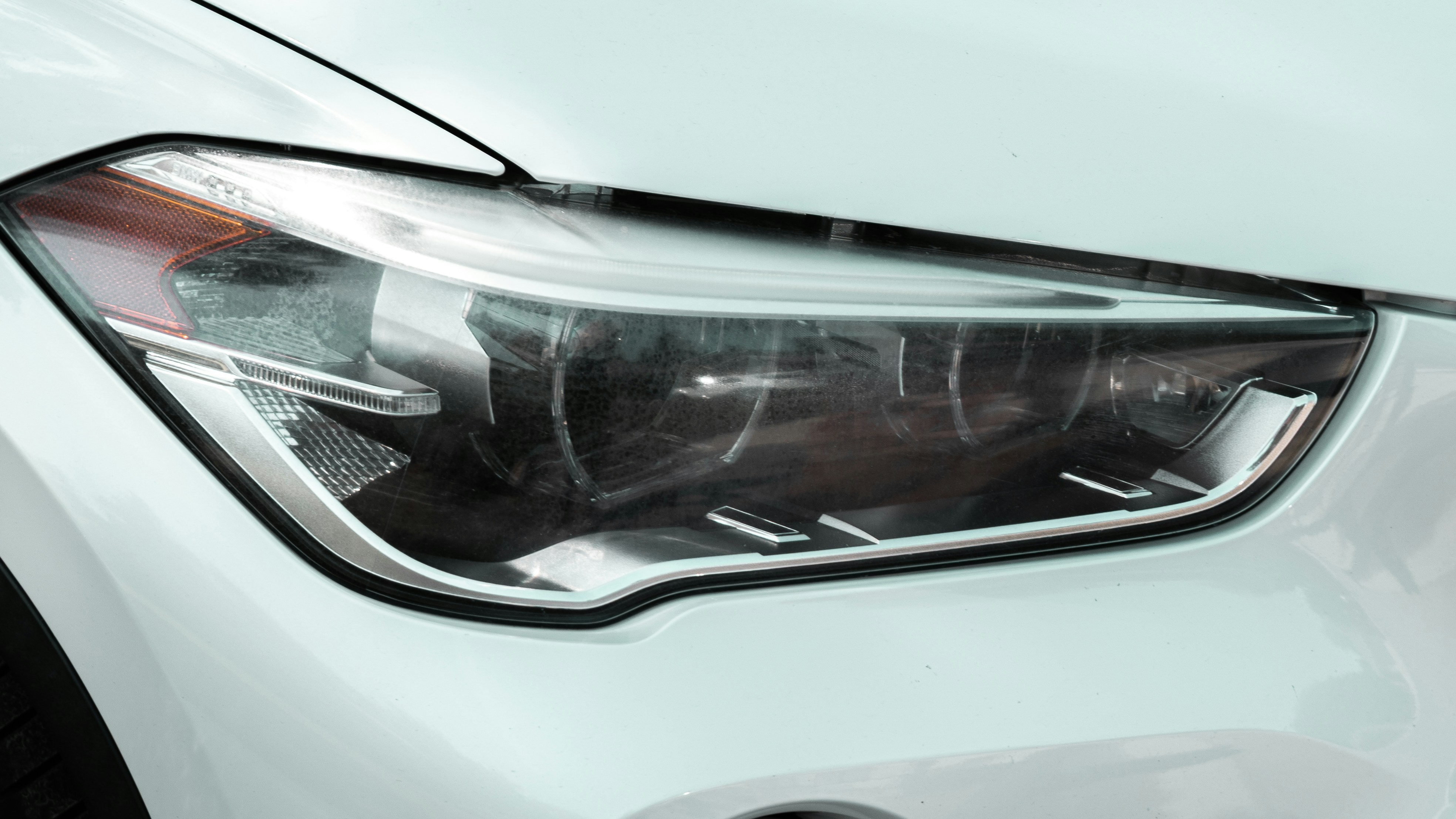 Close-up of a minty-blue car headlight with crisp chrome trim