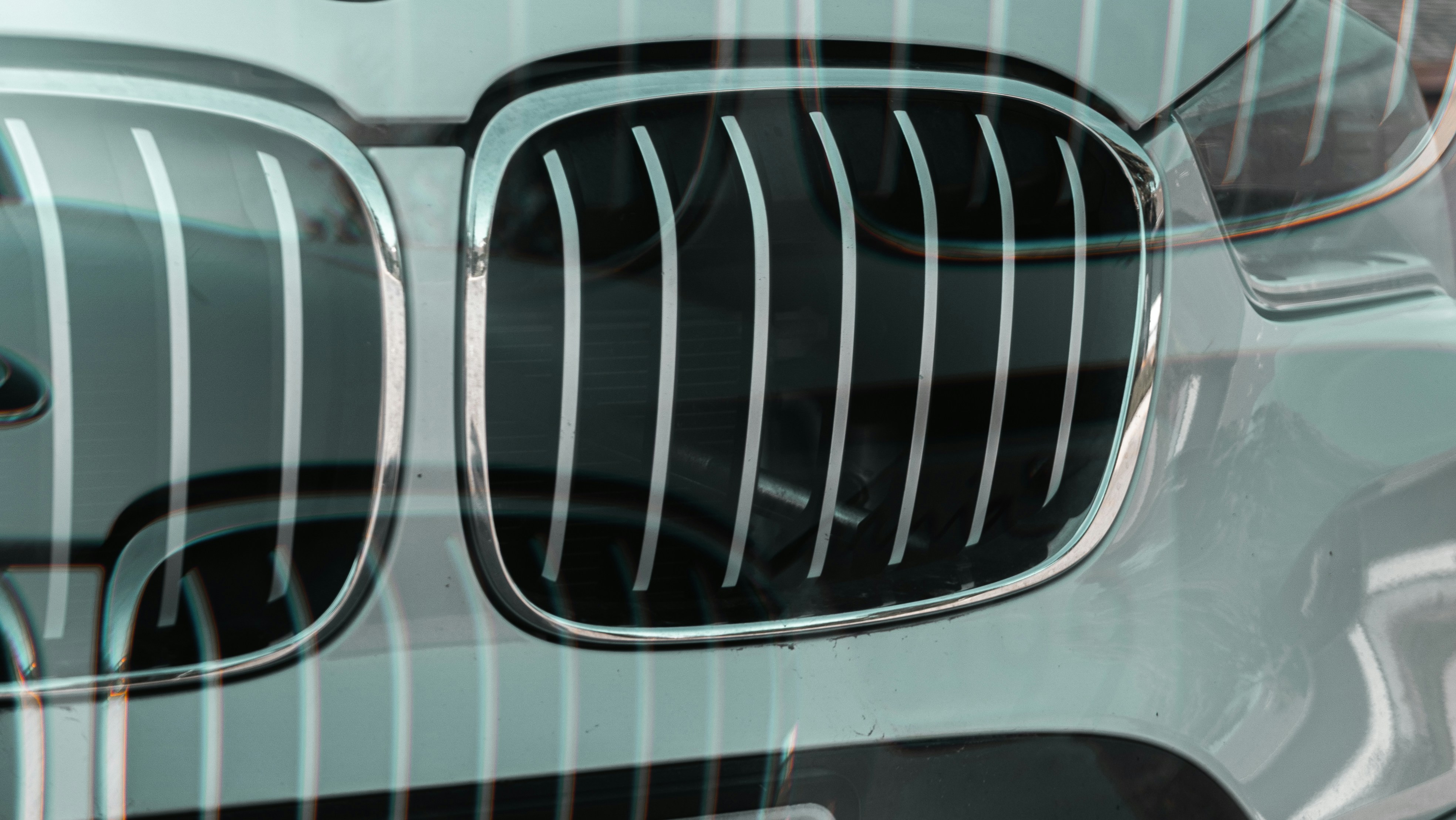 Close-up of a BMW kidney grille under reflective glass