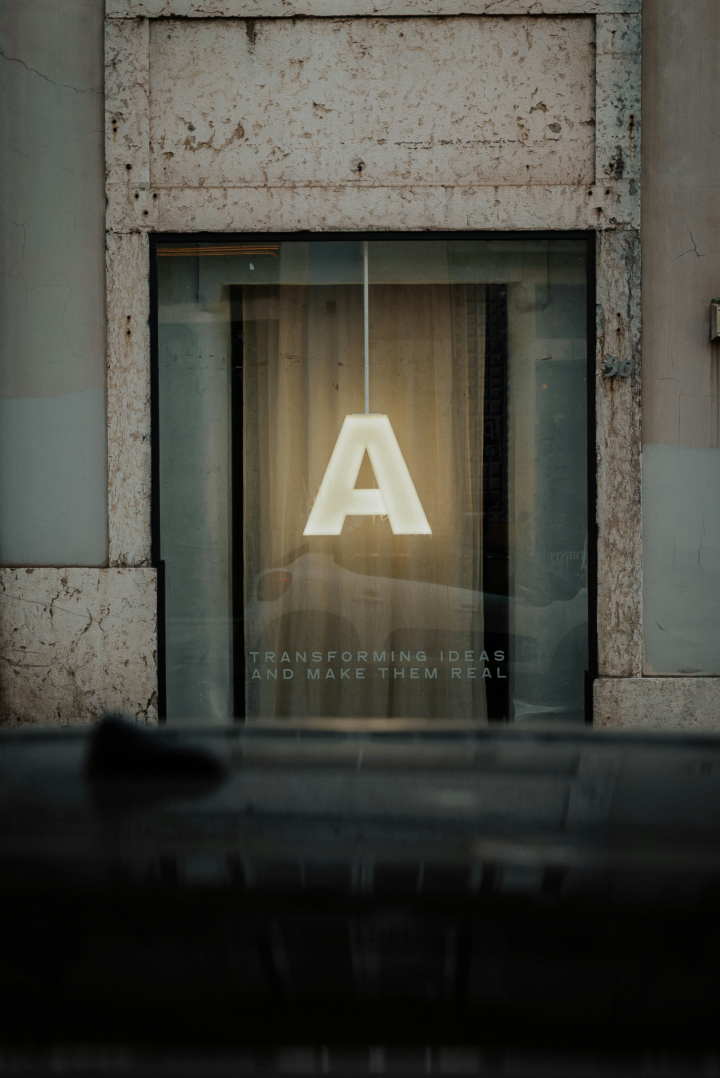 Neon A in a Weathered Window: Transforming Ideas