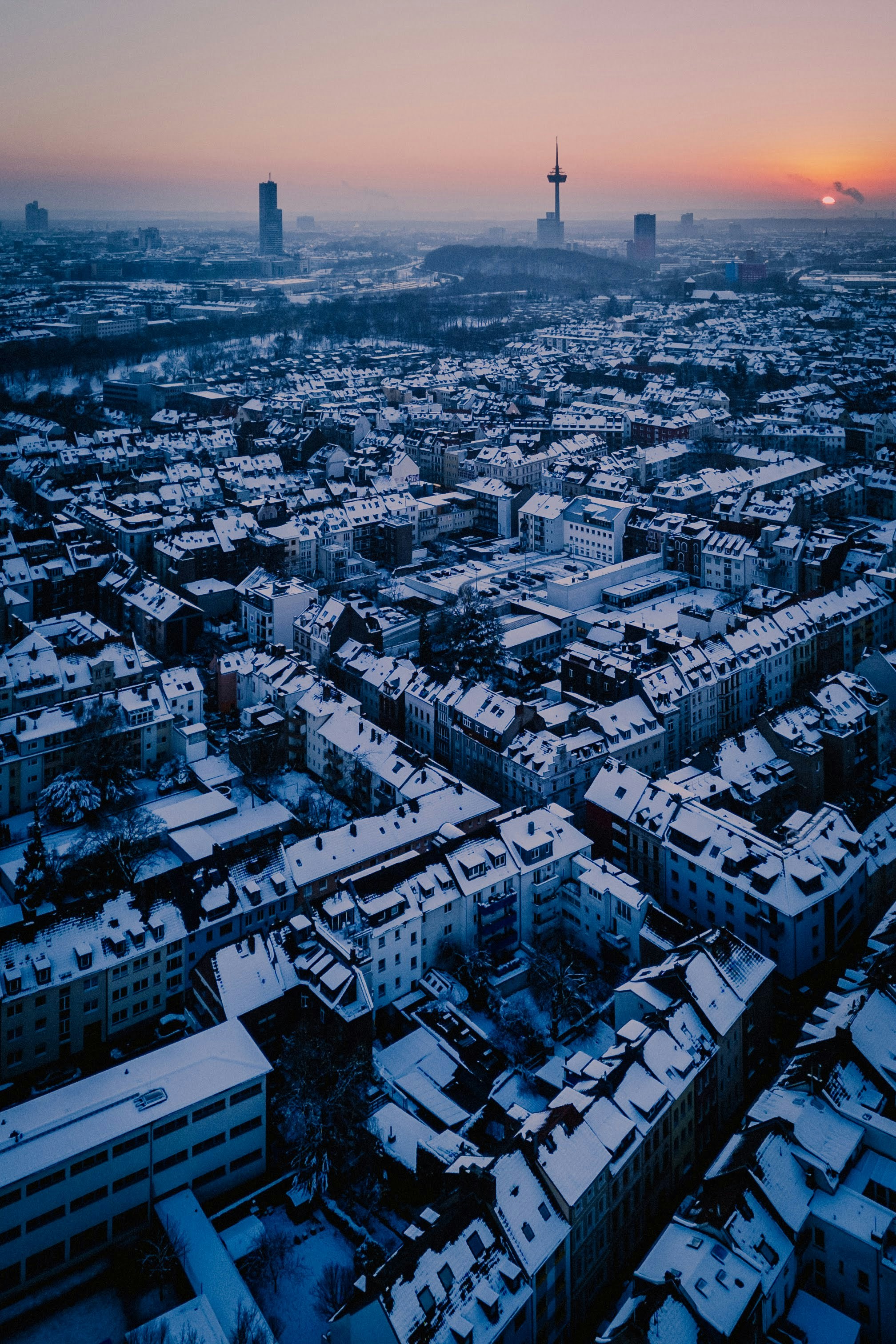 Winter Grid: Snow-dusted rooftops Under a Pale Sunset