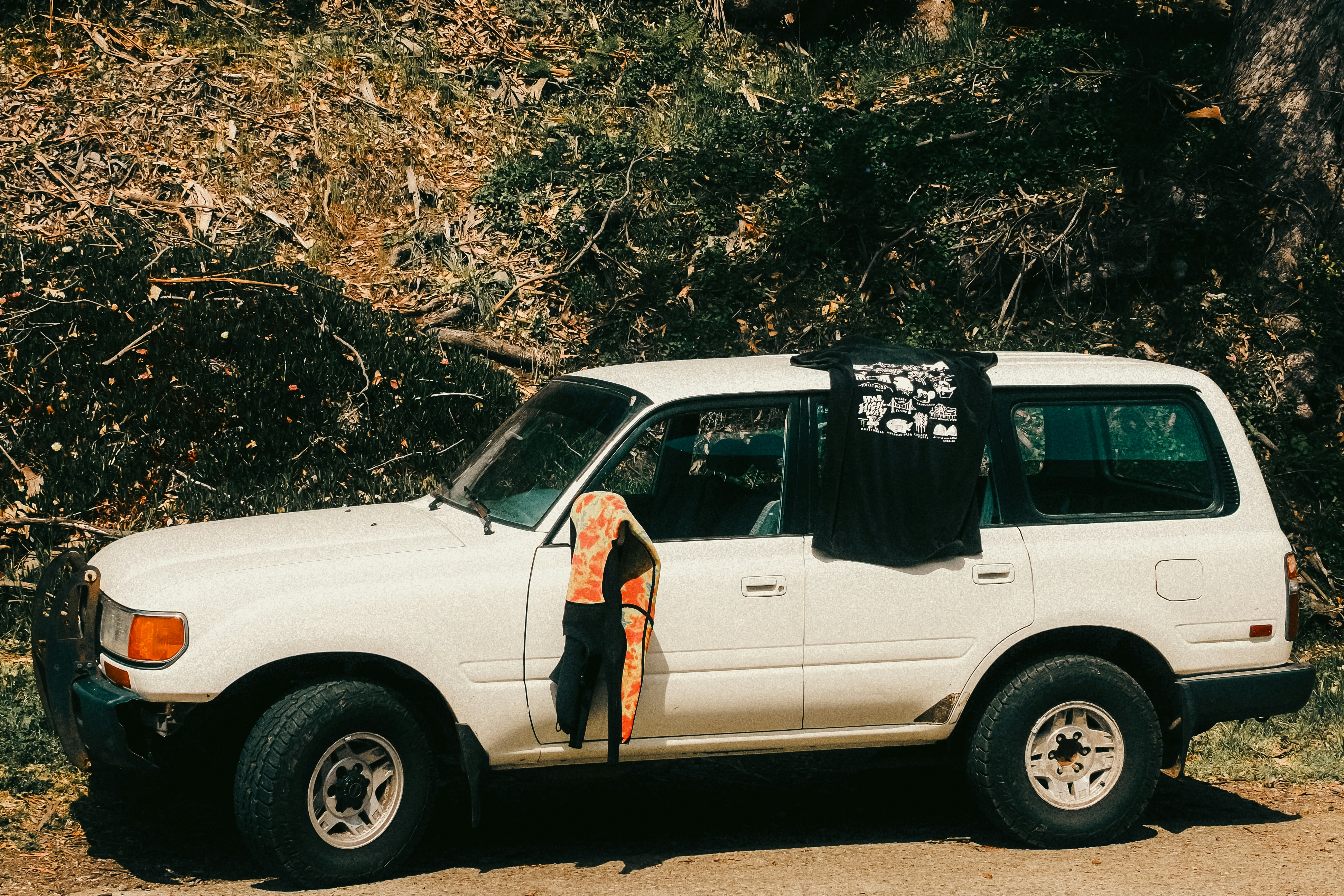 Dusty Drive: A Cream SUV with Laundry Draped Over the Roof