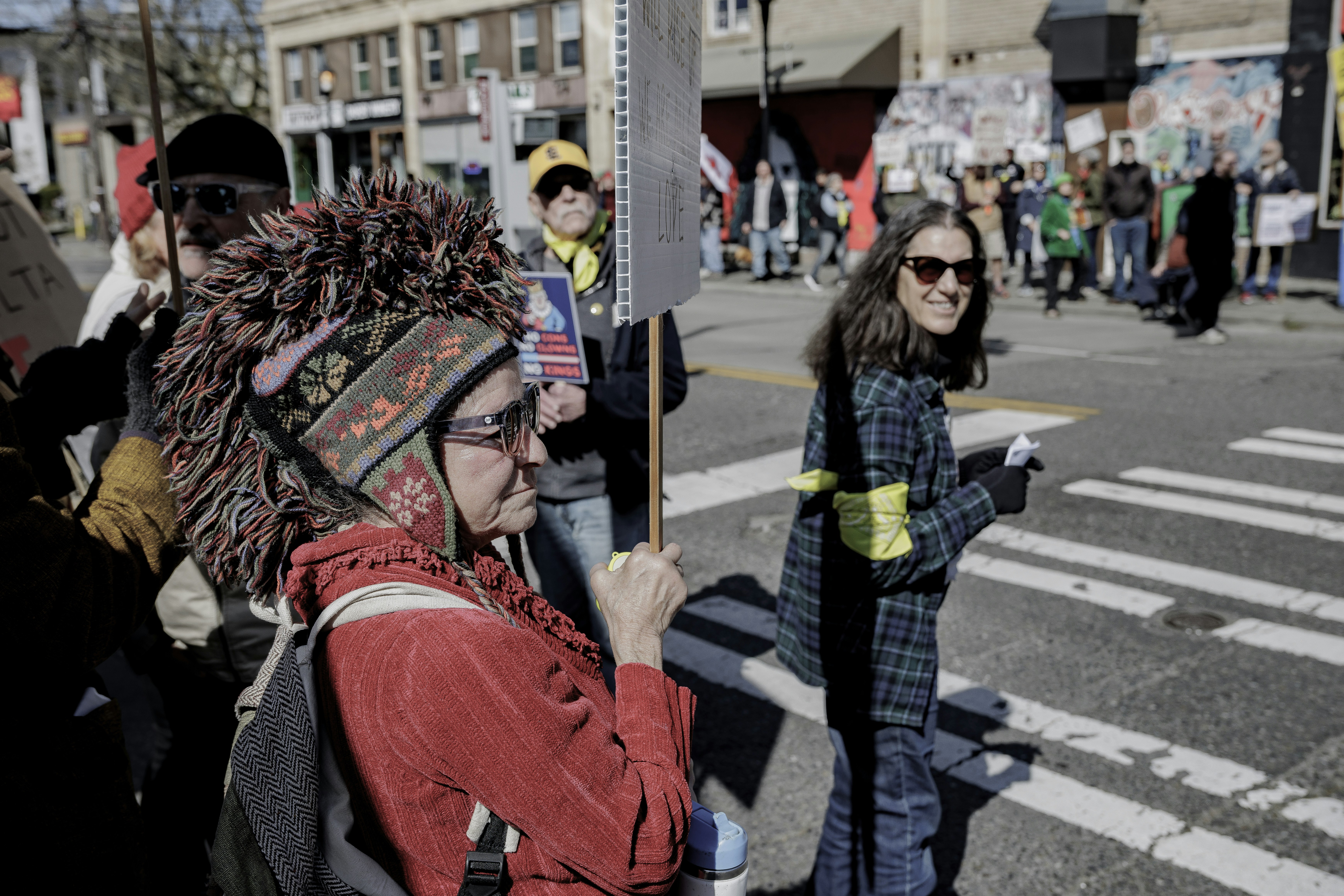 Red-clad protester with sign near intersection.