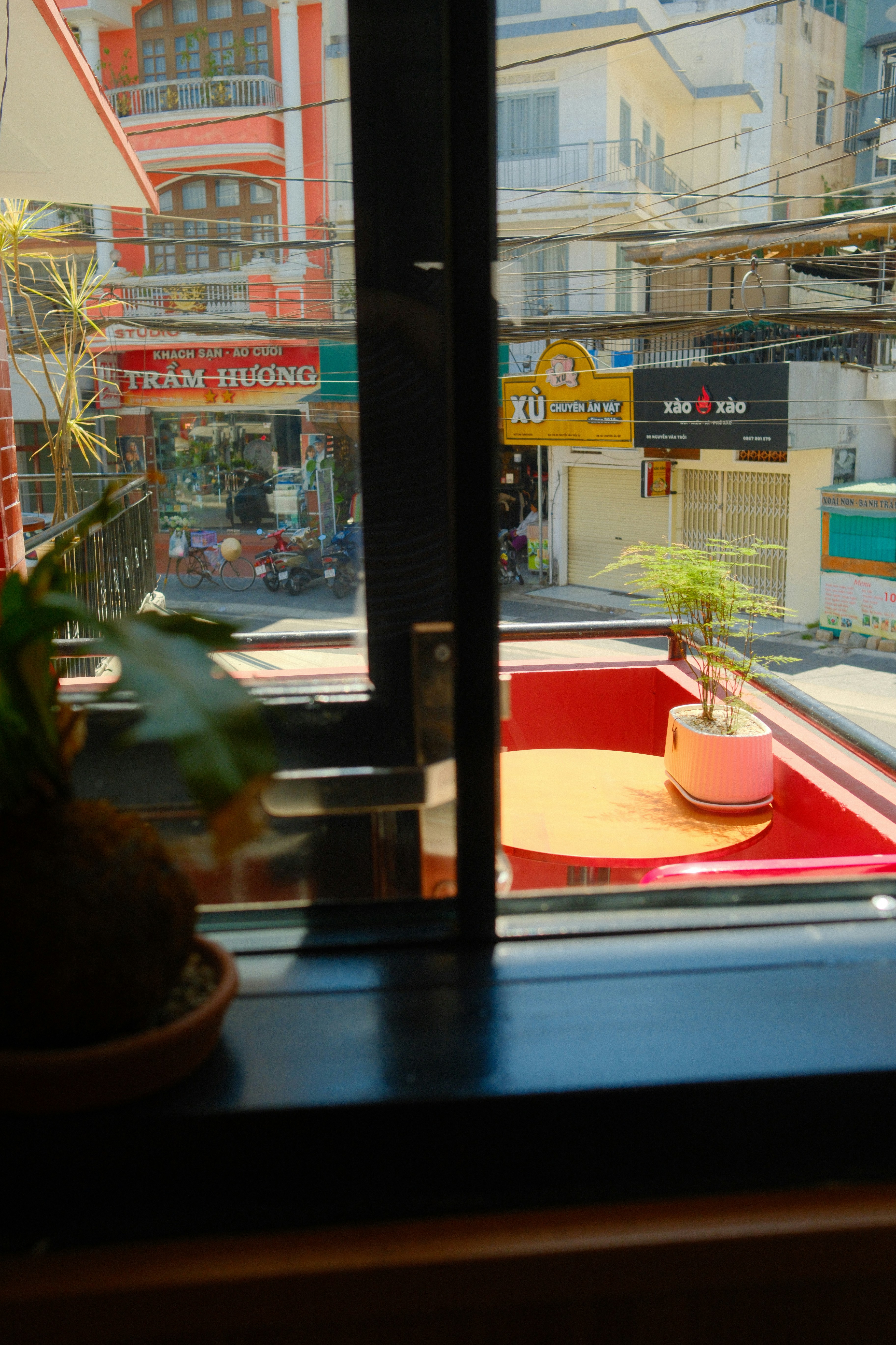 Through the Window: Street Studio Hues and Red Balcony