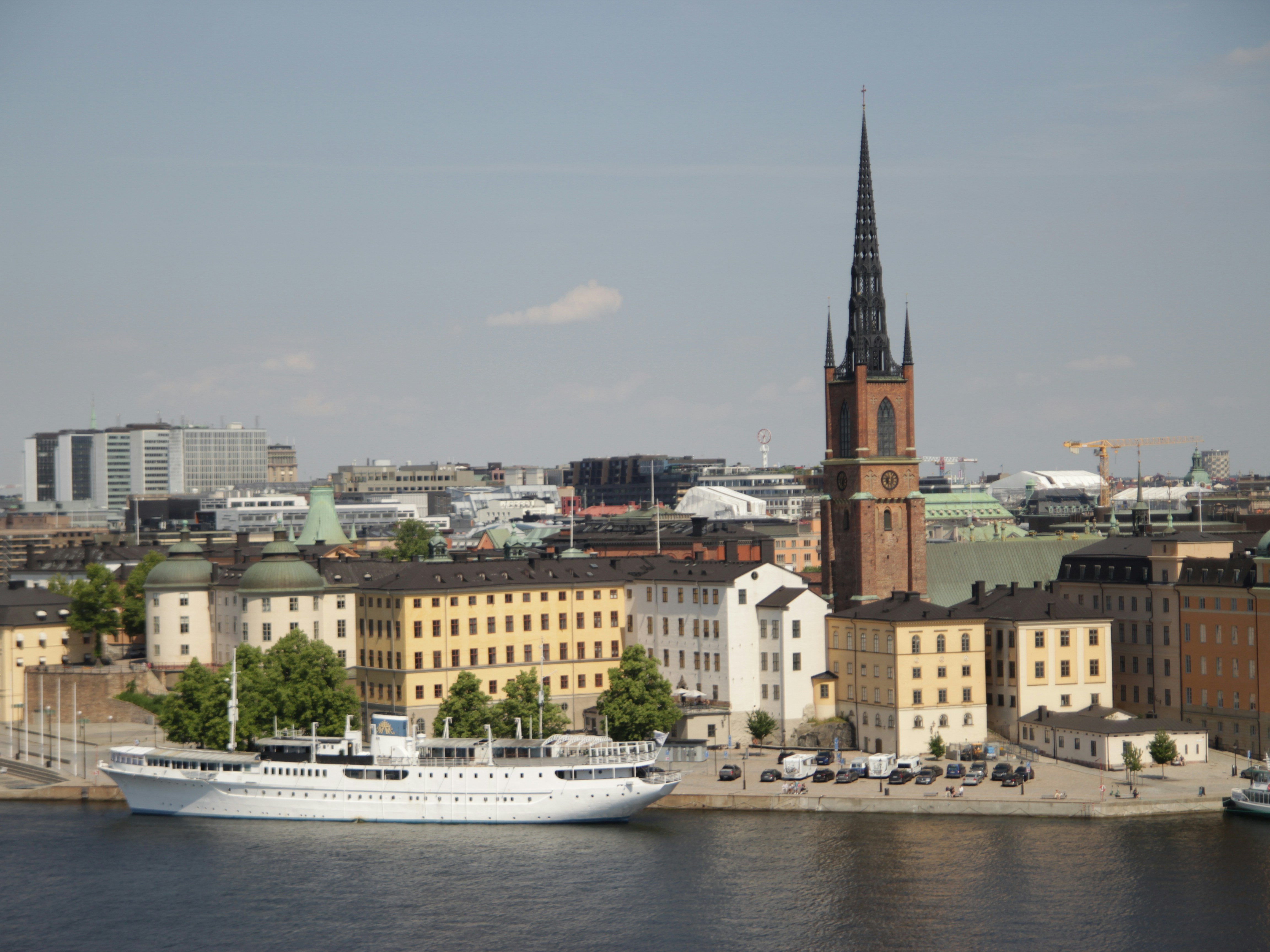 Harborfront Cathedral: Boats, Brick Facades, and a Tall Spire