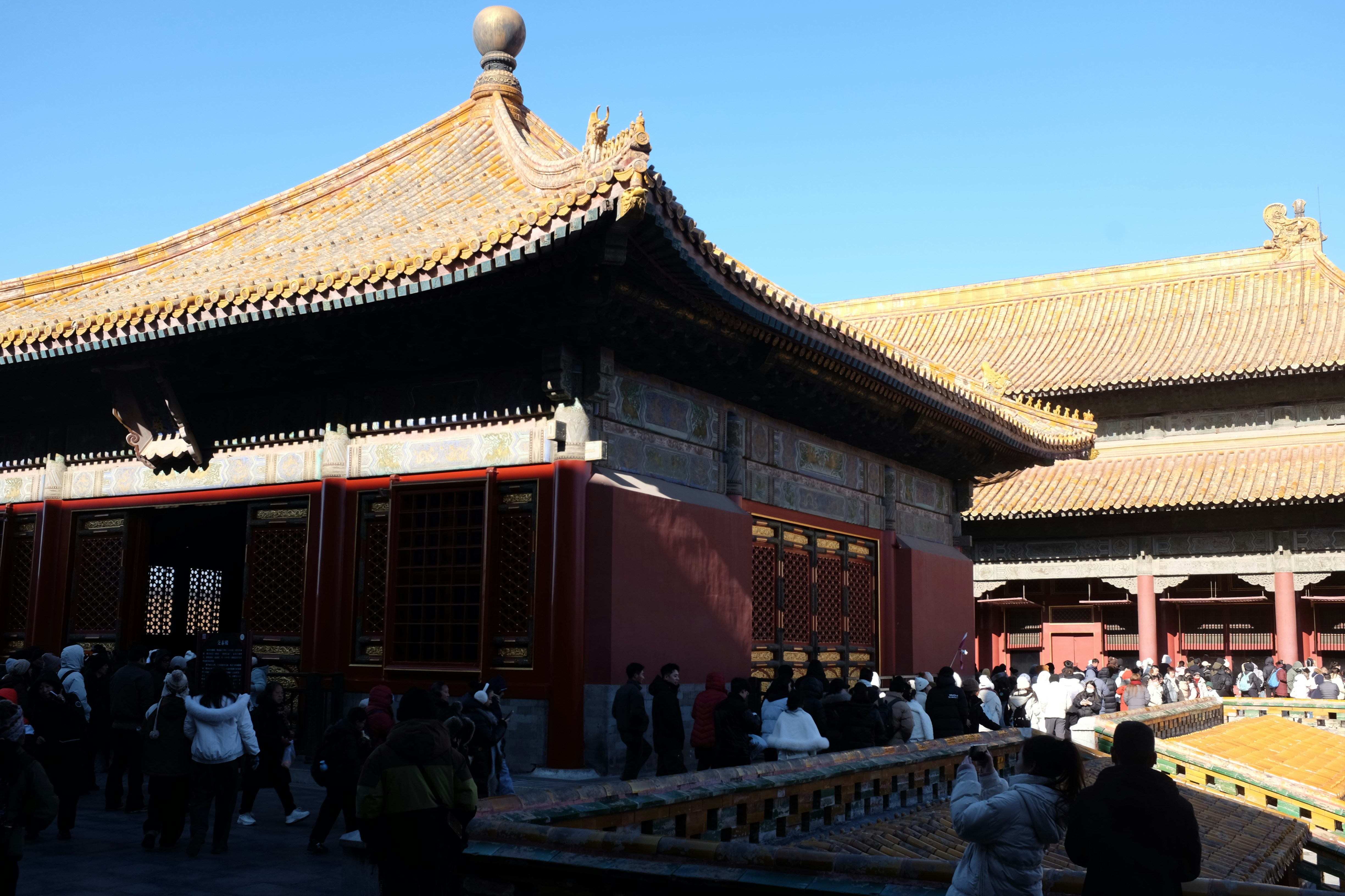 Courtyard Echoes: Visitors Amid the Golden Rooftops