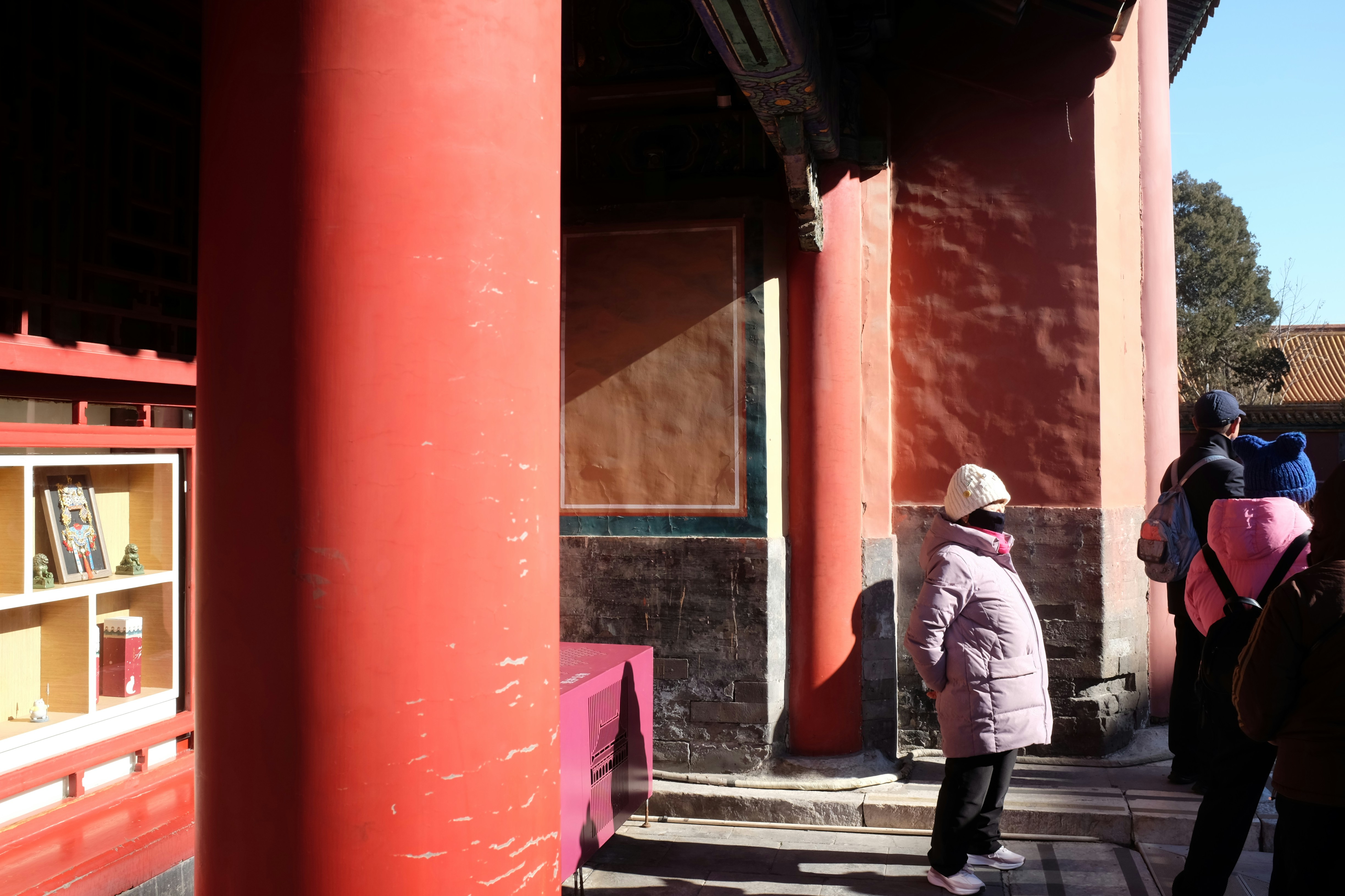 Scarlet Columns and Quiet Visitors at a Temple Exterior