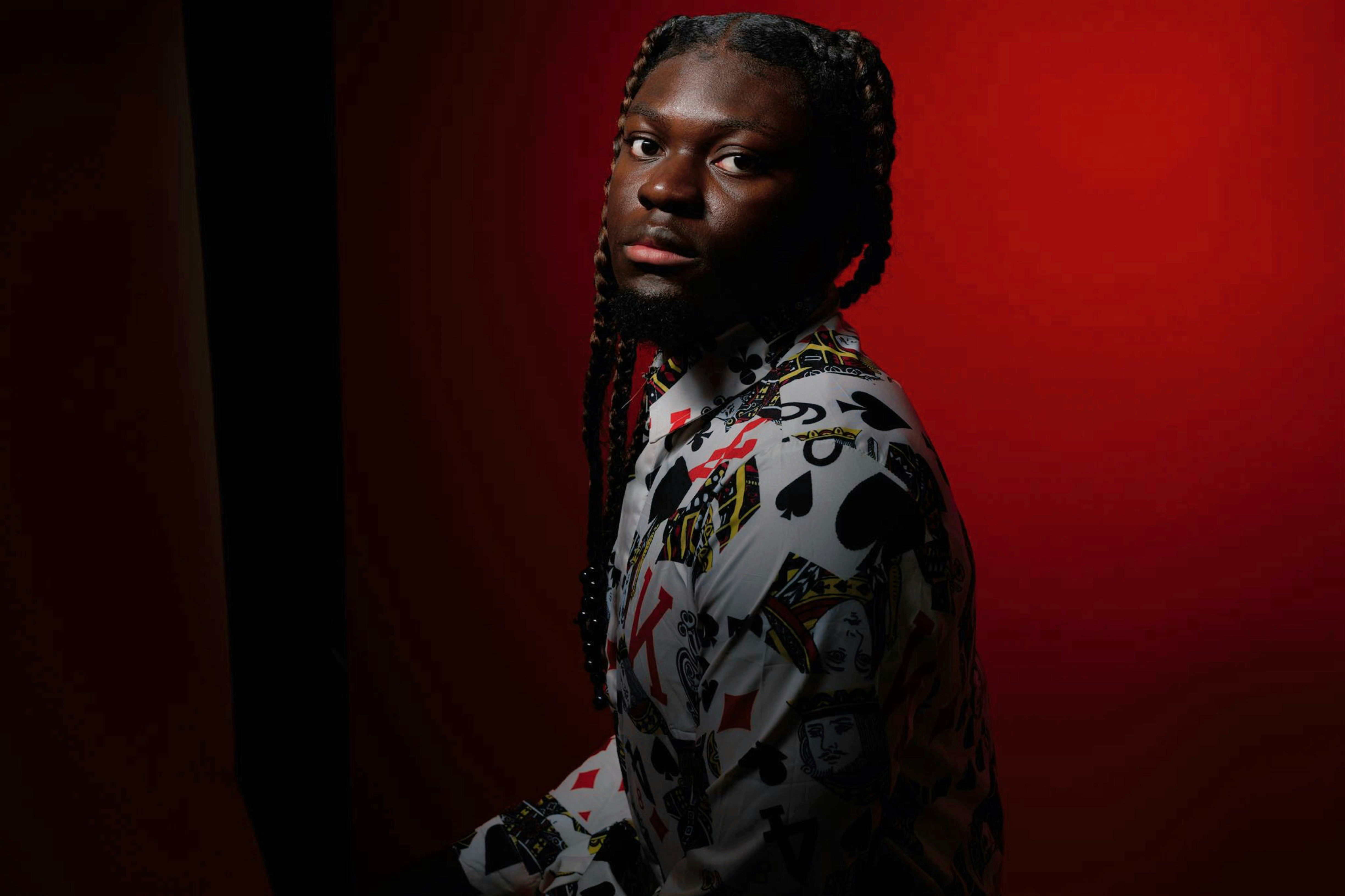 Portrait in Red: A Confident Gaze Beneath Bold Patterned Attire