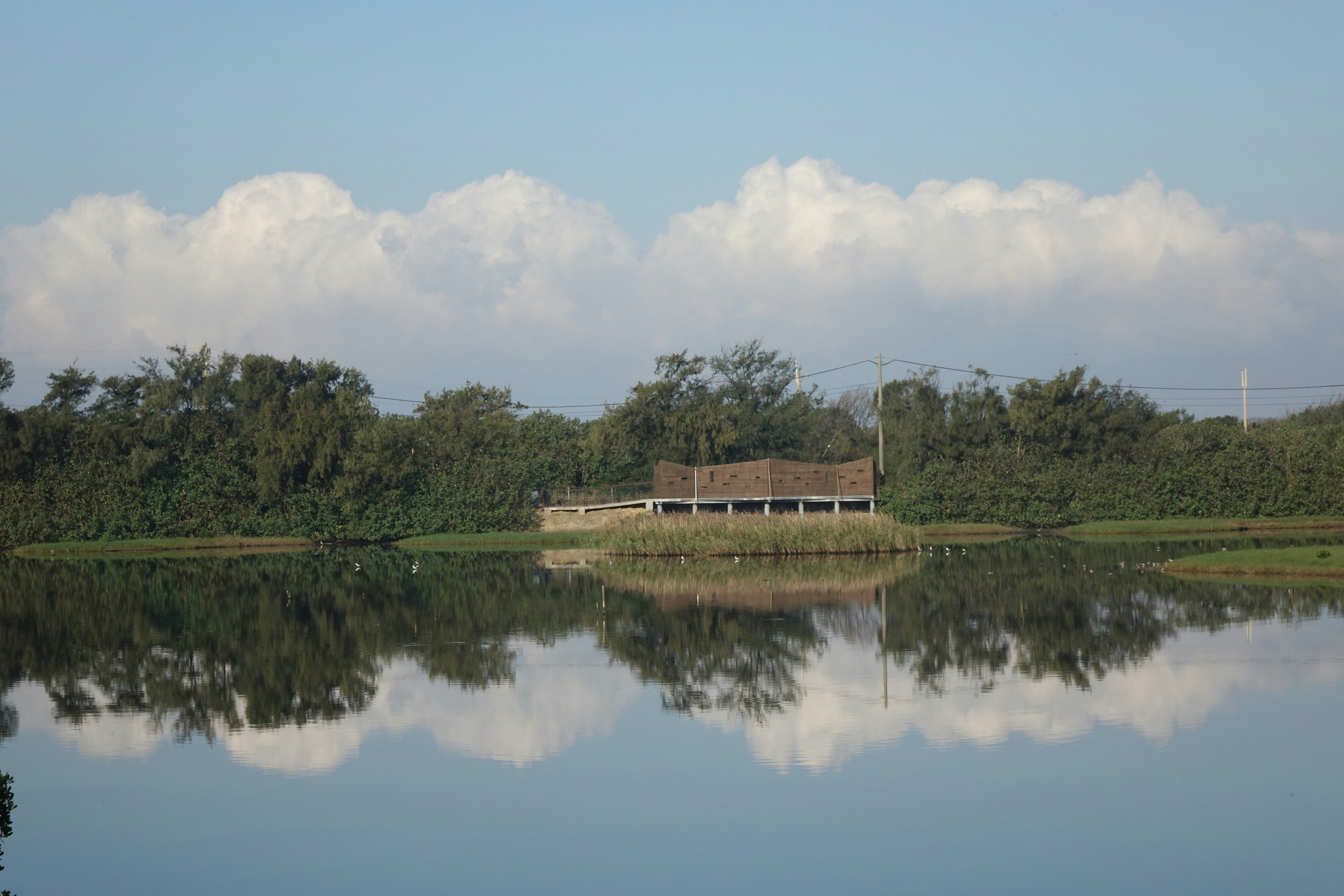 Serene Lakeside Hut Mirrored in Calm Waters