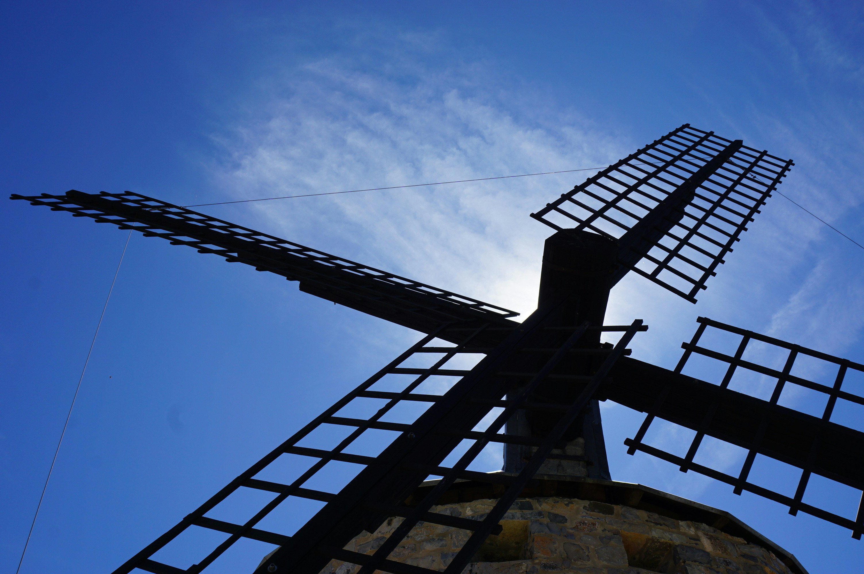 Silhouette of a Windmill Reaching Toward a Bright Sky