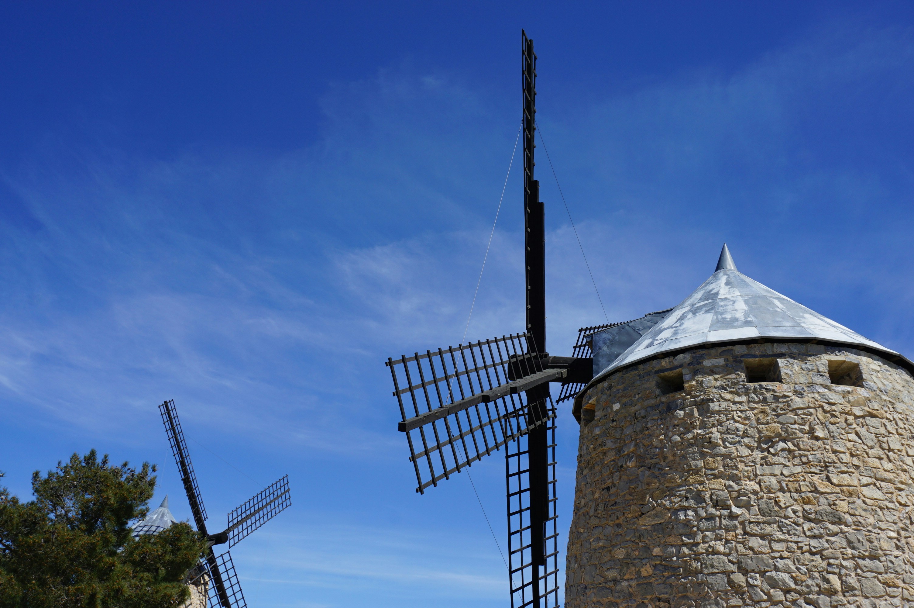 Stone Windmill Sentinel Under a Brisk Blue Sky