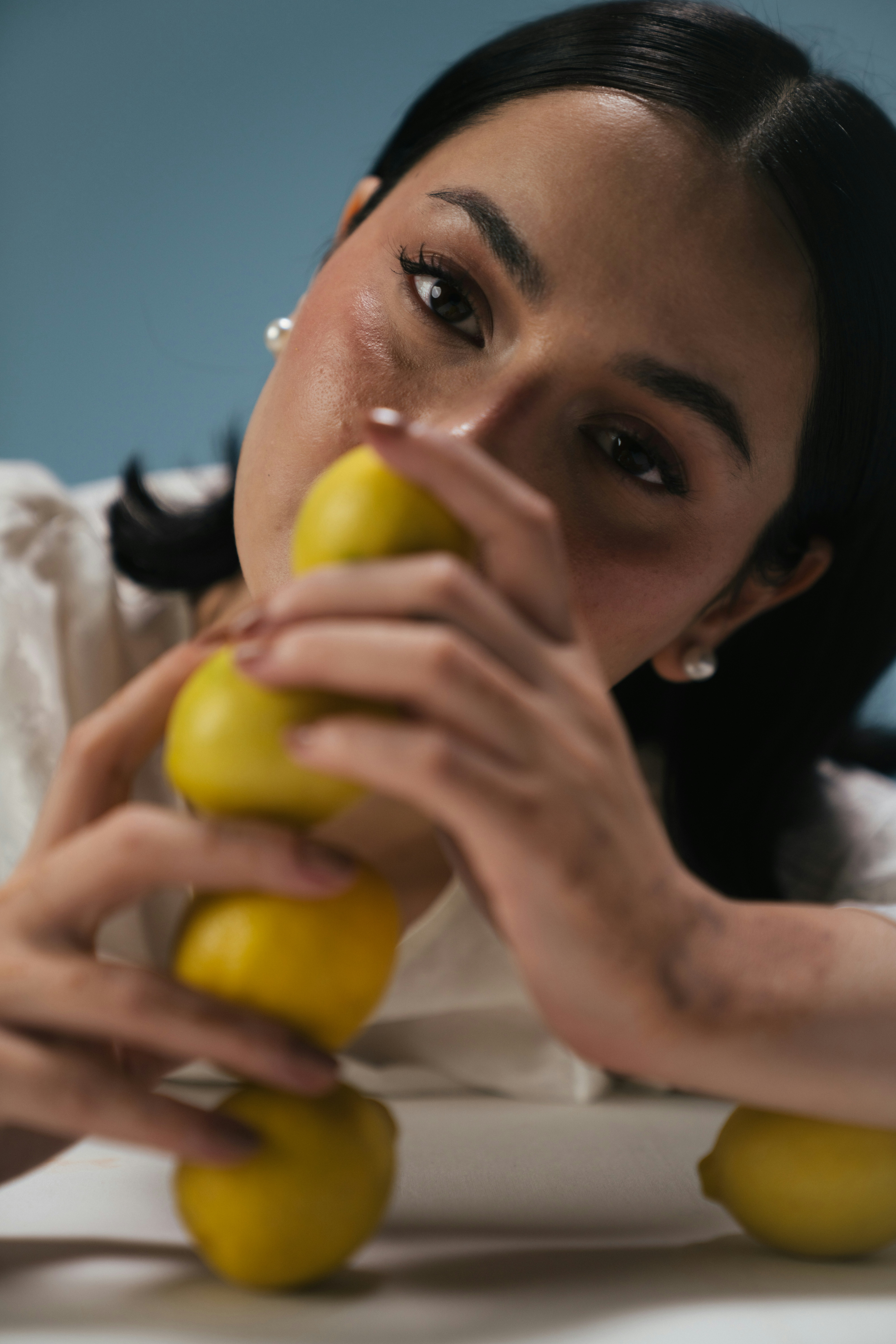 Close-up of a contemplative gaze framed by lemons