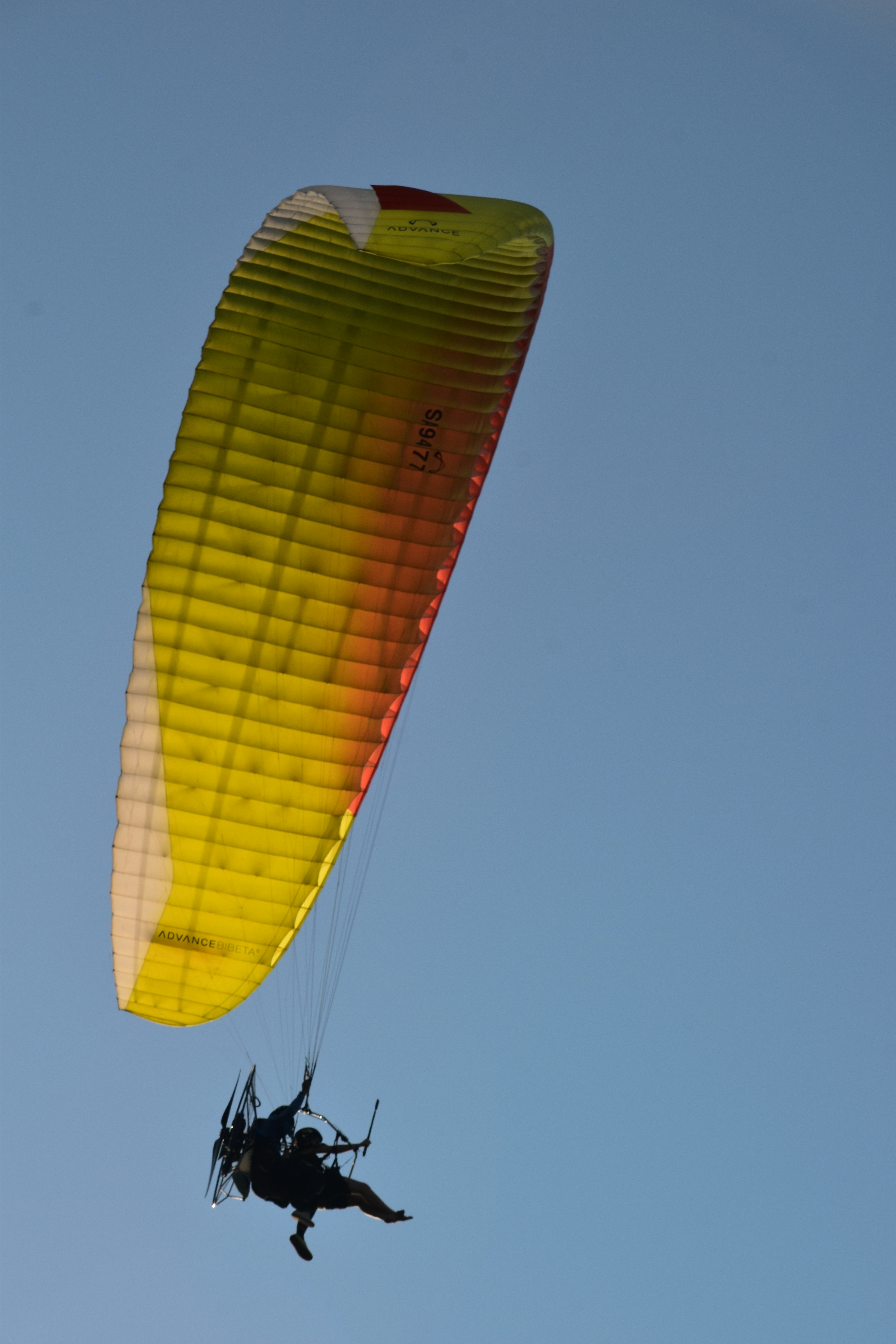 Yellow-Red Paraglider Against Clear Sky