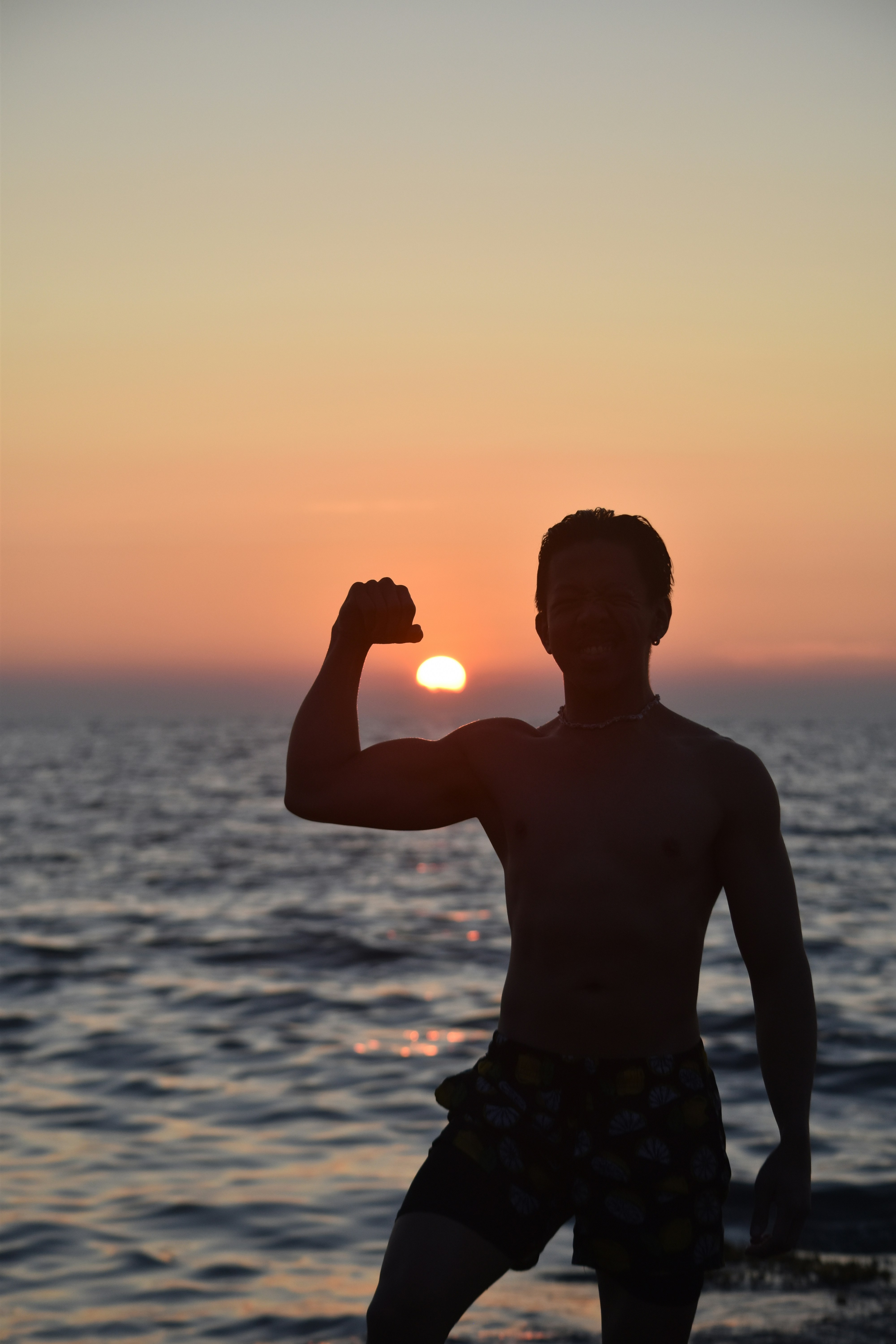 Sunset Silhouette: A Sailor's Strength by the Sea
