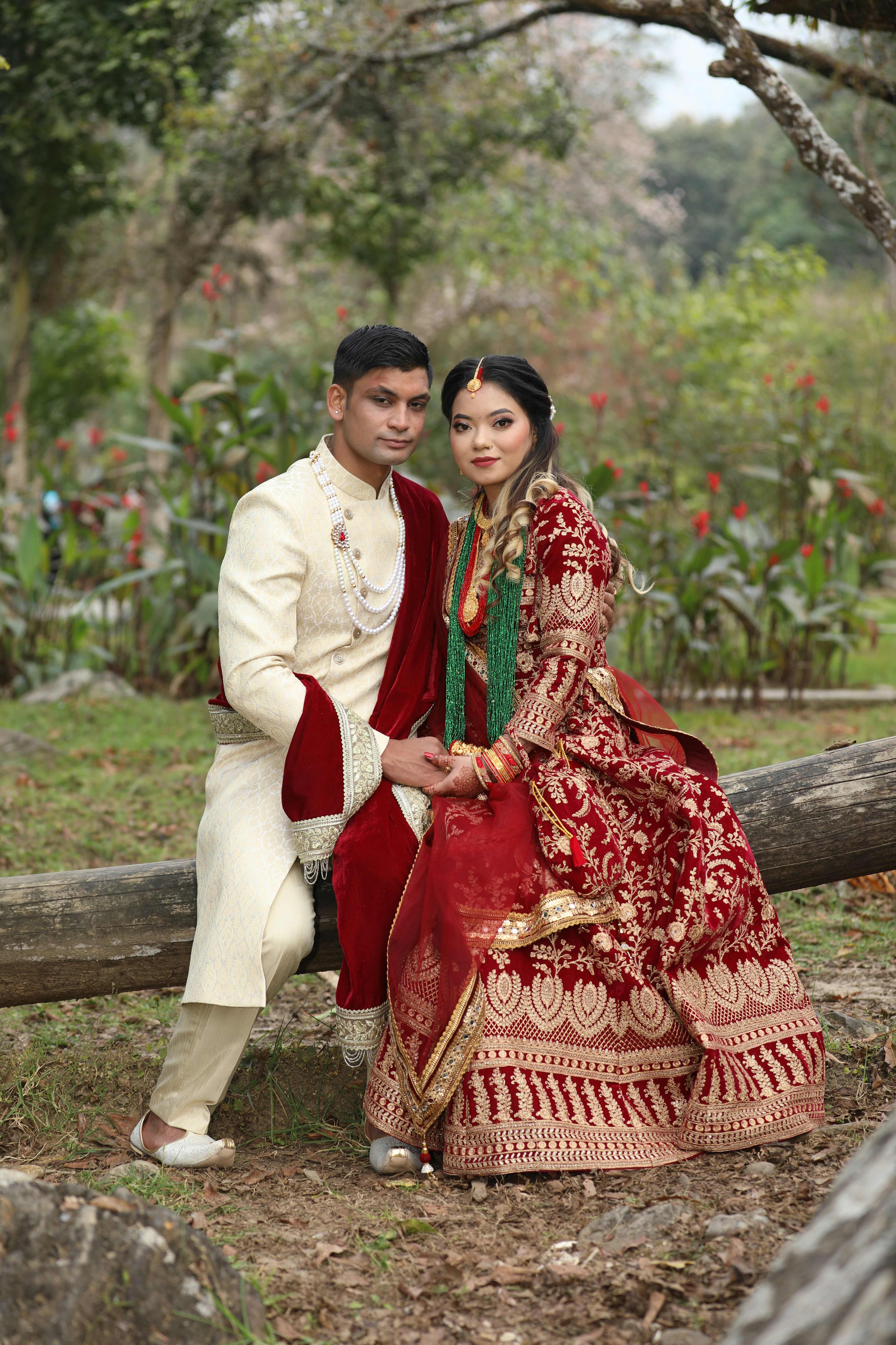 Couple in Traditional Attire Rest Amid Garden Spring