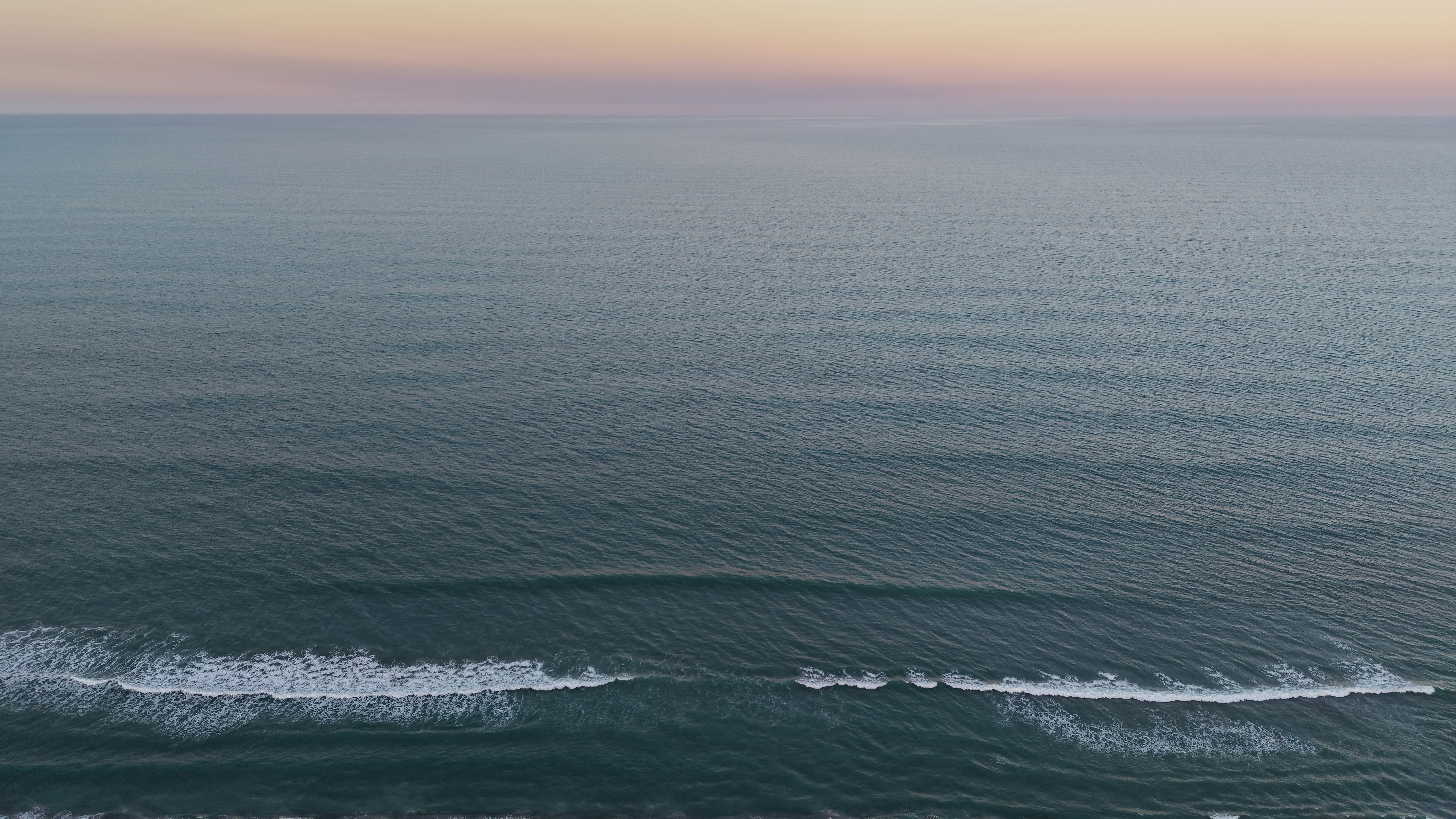 Calm Horizon: Gentle Ocean Ripples at Dusk