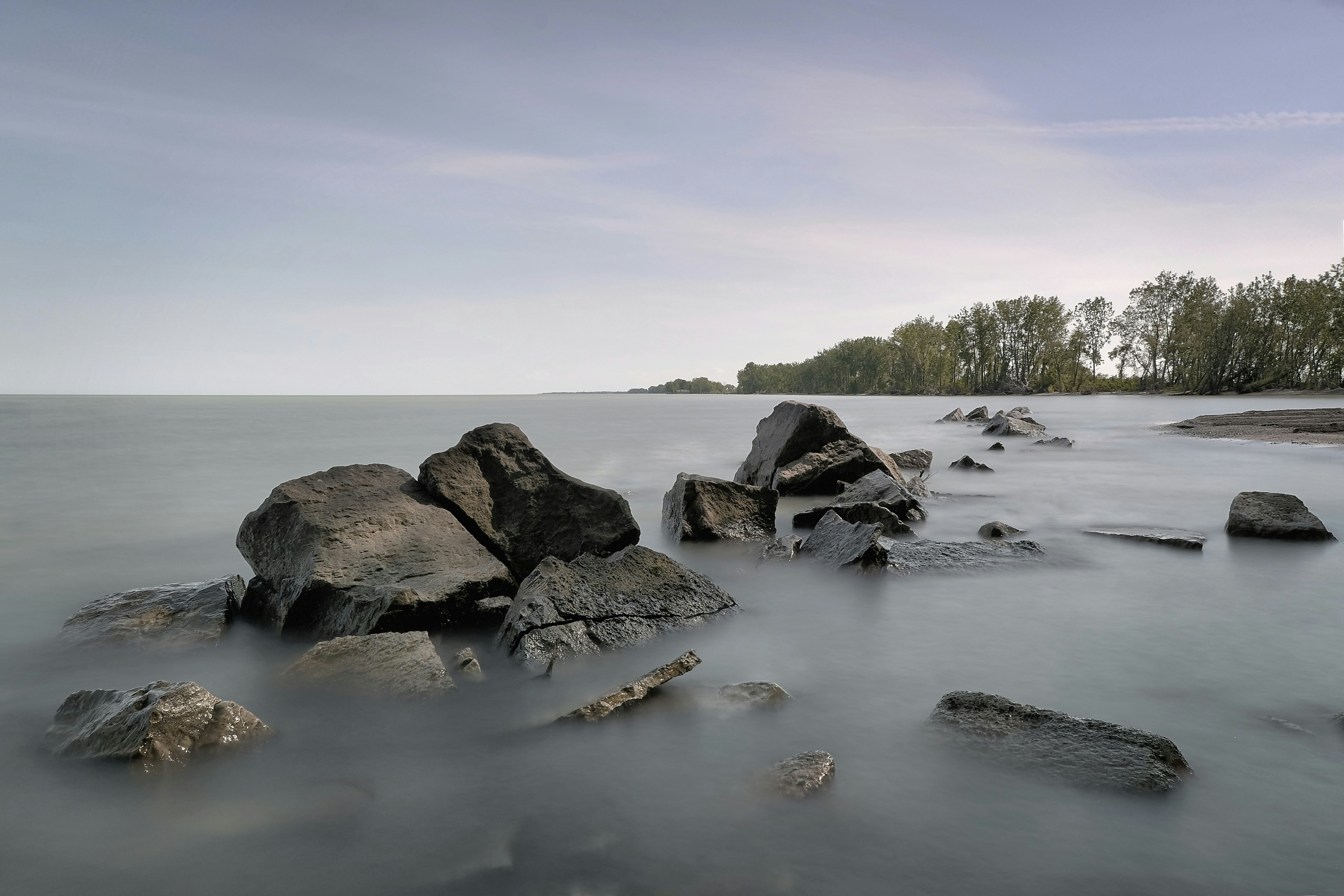 Rocks Carve a Quiet Coastline Under a Gentle Sky