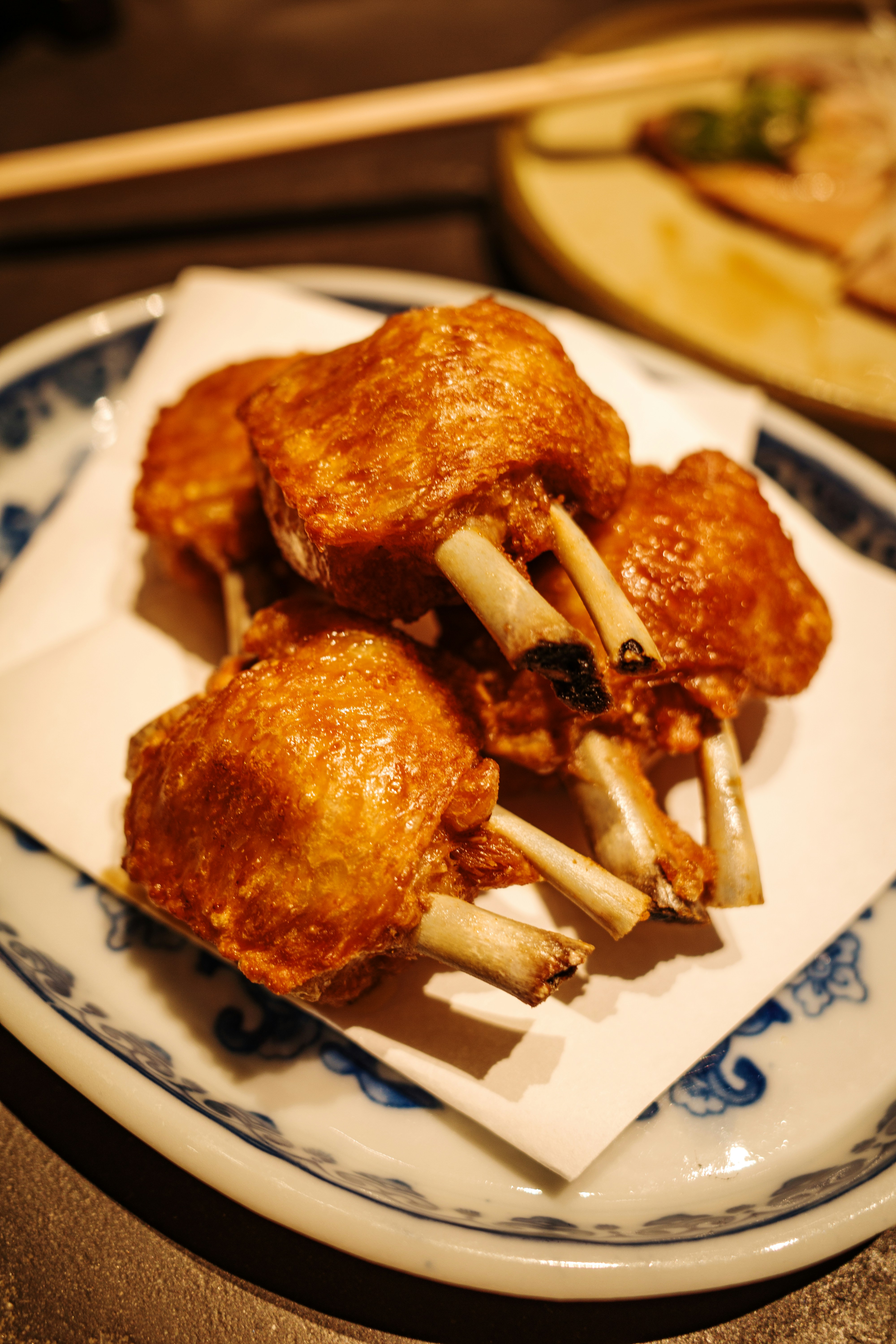 Crispy skewered morsels: fried meat bites on a blue porcelain plate