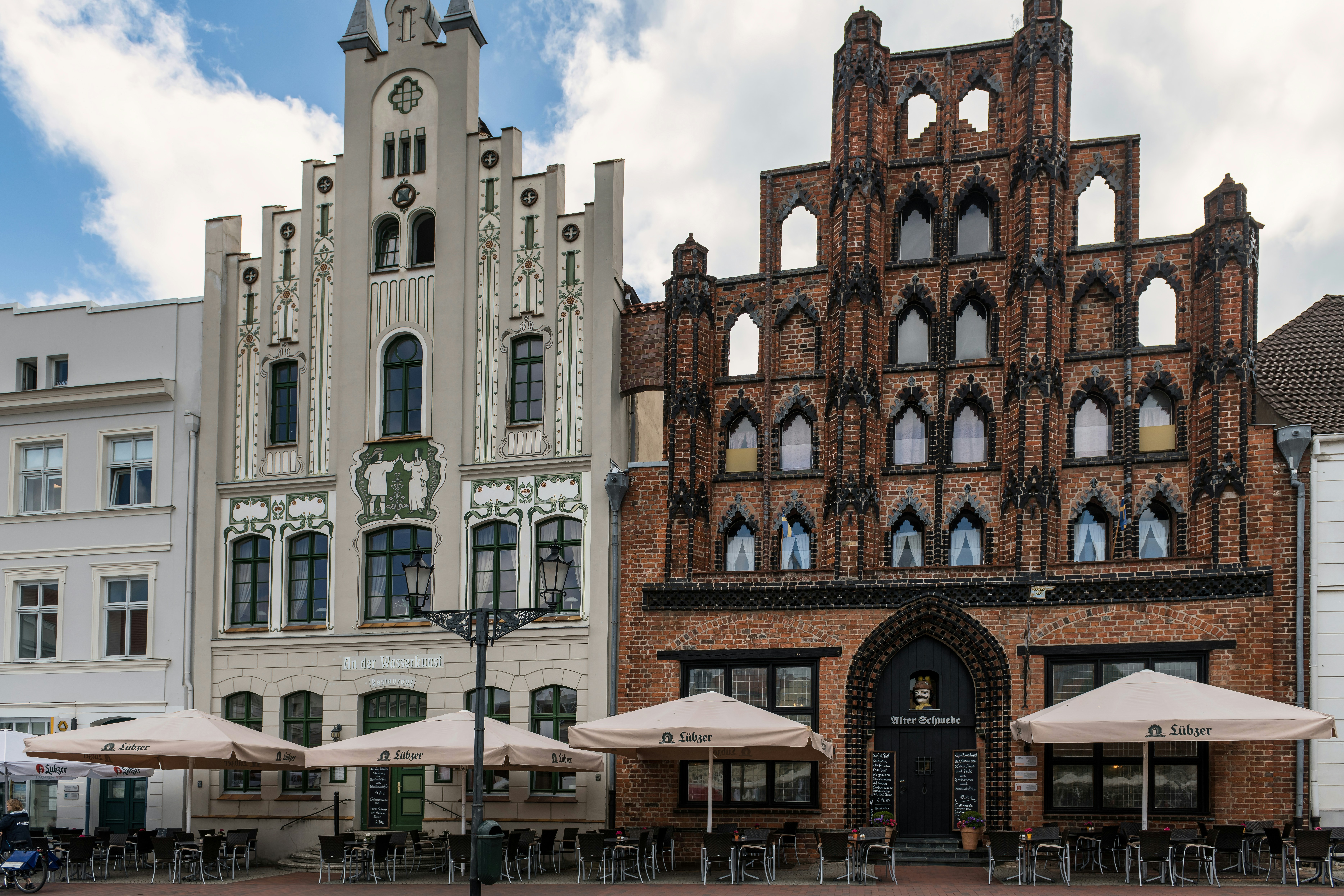 Duet of Facades: A Historic Row with Café Terrace under Bright Sky