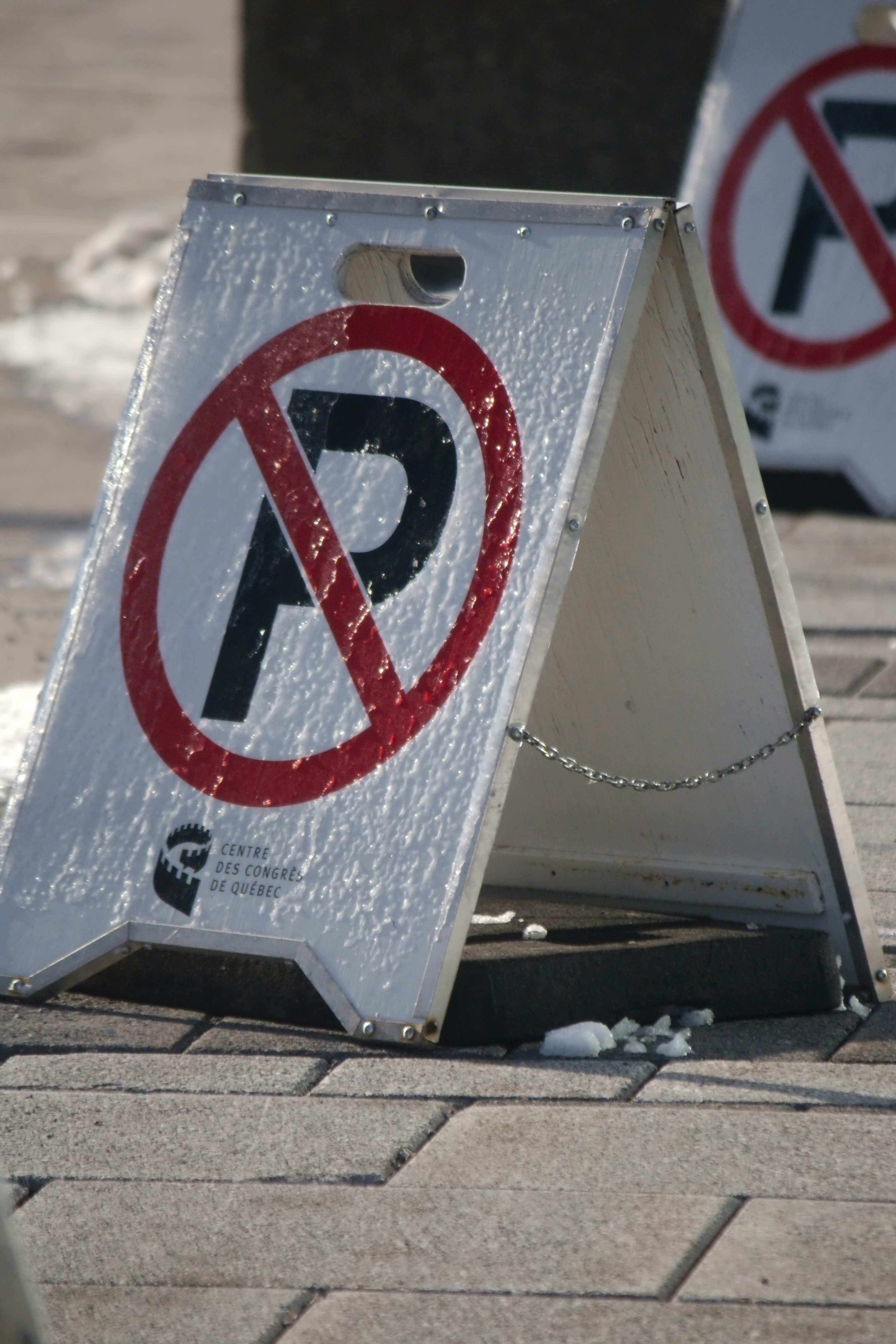 Overturned No-Parking Sign Framed by a Repeating Warning in Snow