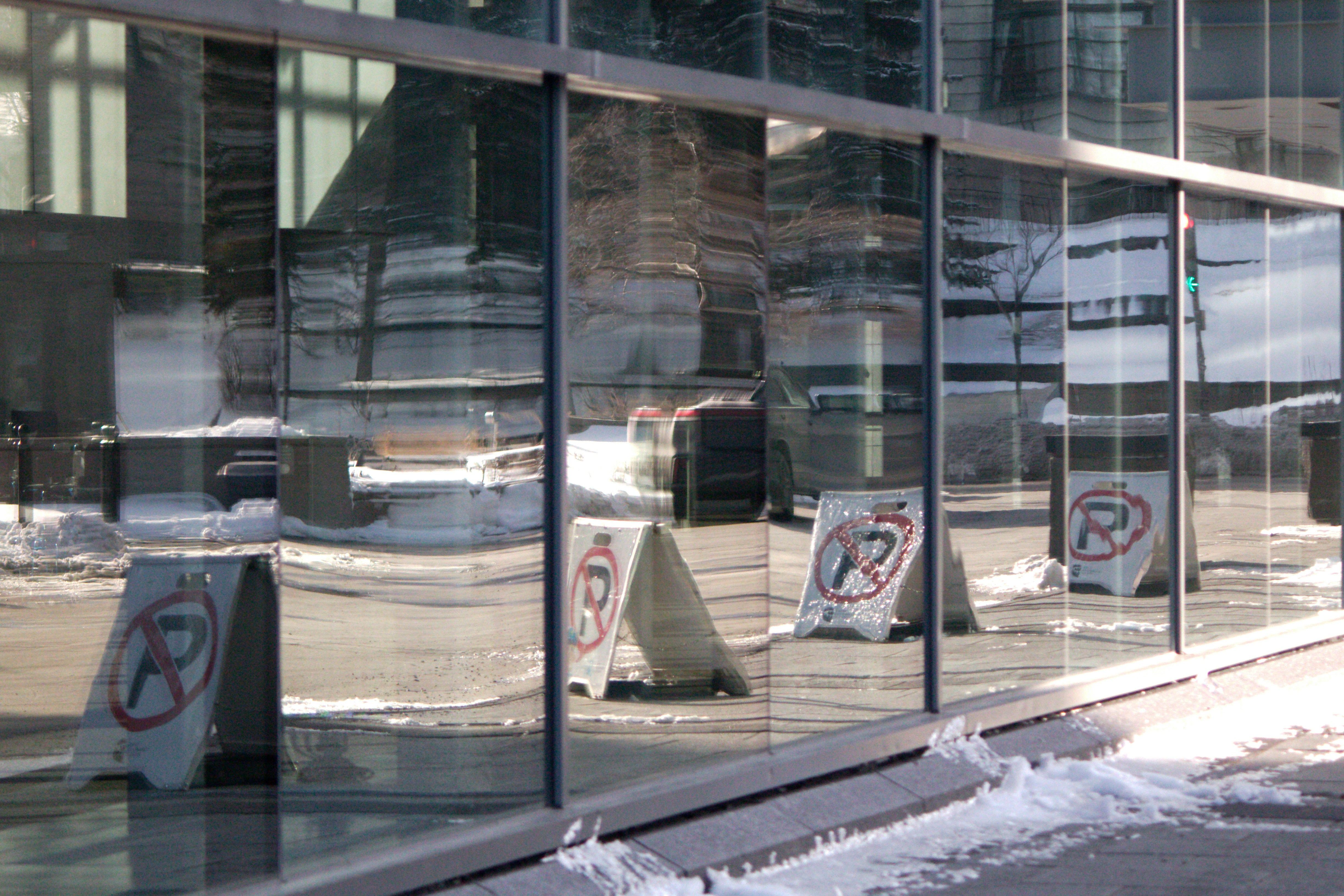 Reflections at the Glass Front: Snow Debris and No-Parking Signs