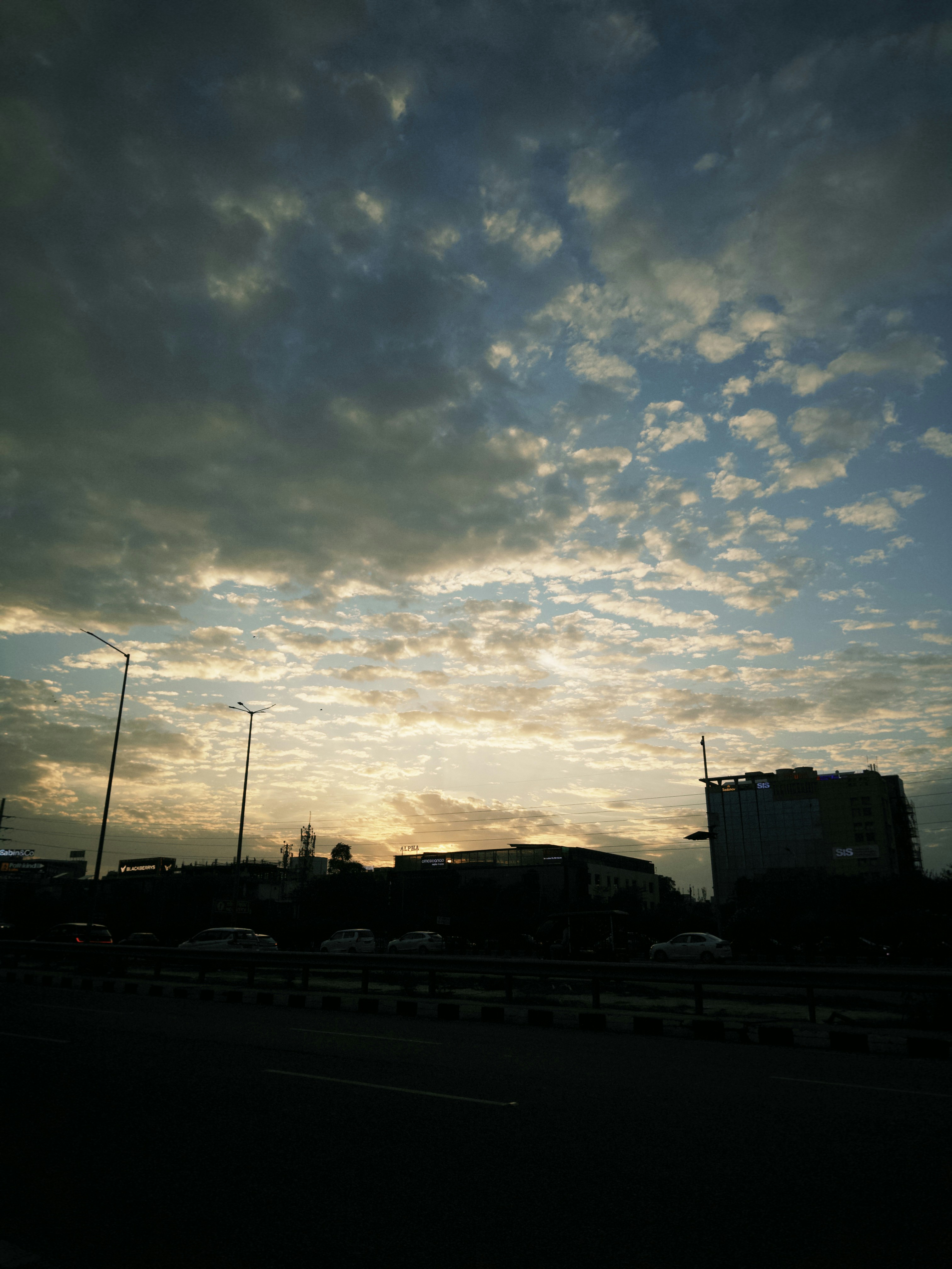 Sunlit Skyline at Dusk: A Quiet Highway Under a Cloud-Laced Sky