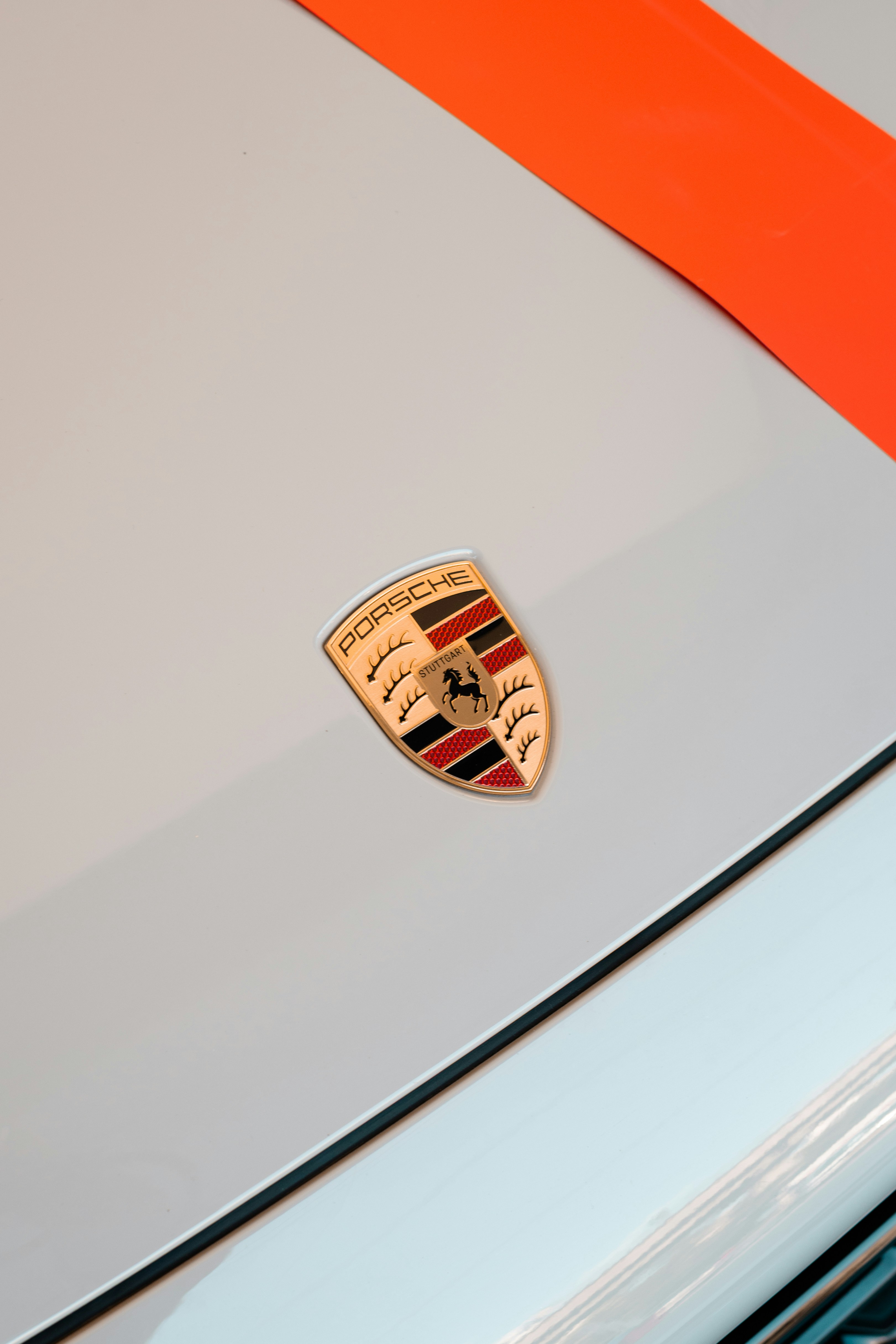 Emblem in Focus: The Porsche Crest on a Silver Hood