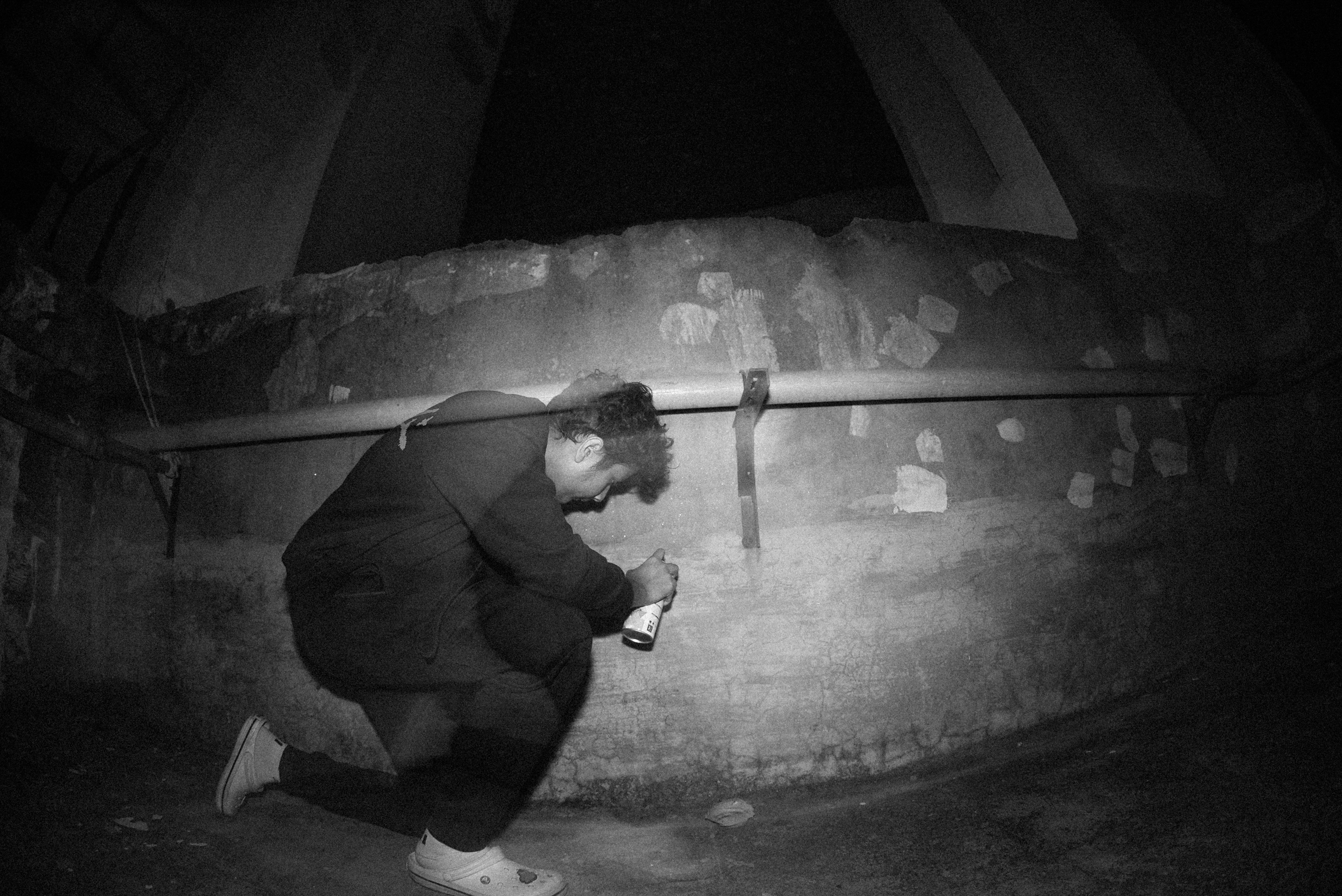 Nighttime Surfer in a Concrete Tunnel: A Glimpse of Quiet Curiosity