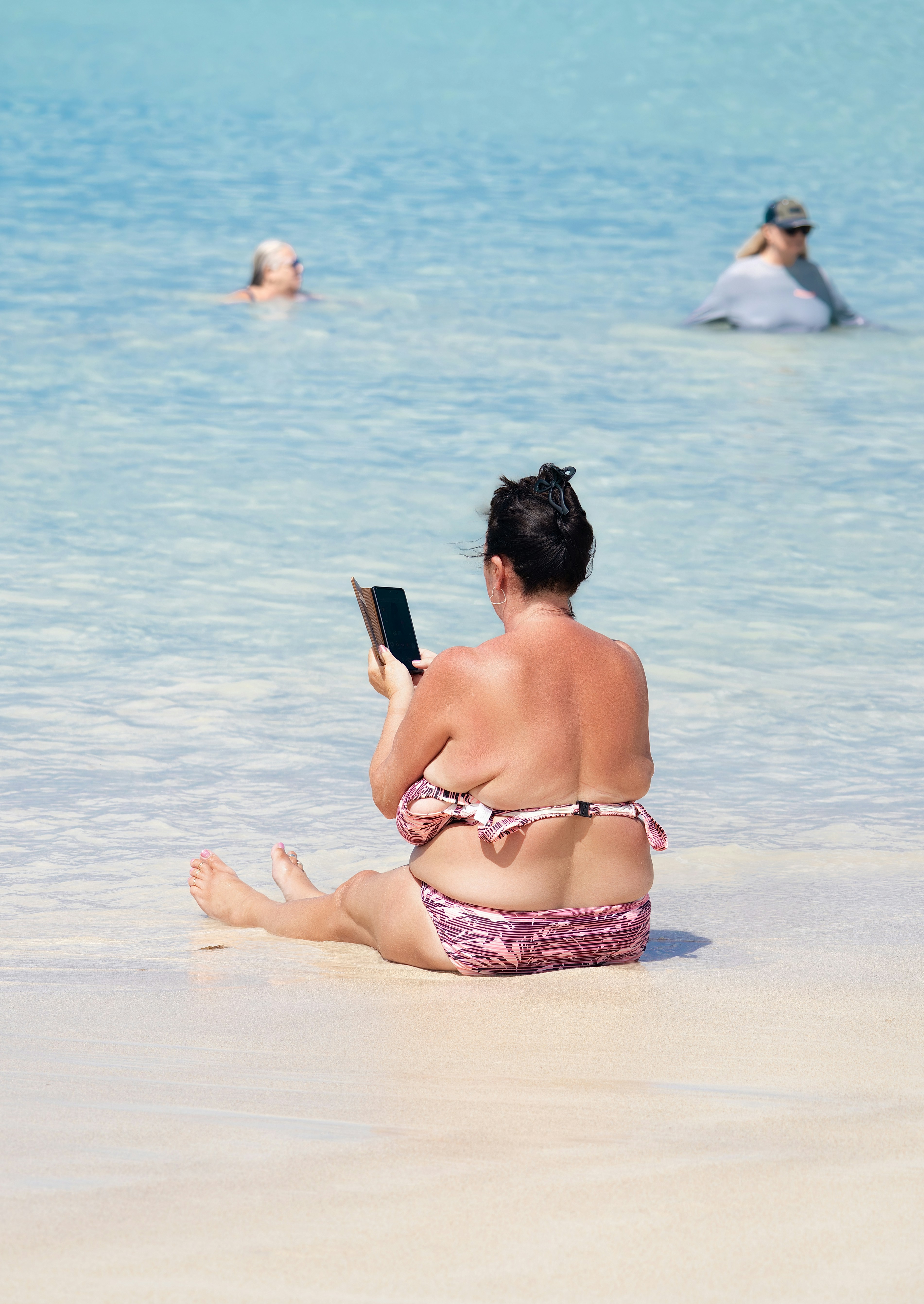 Sunlit Shoreside Reader: A Quiet Moment by the Sea