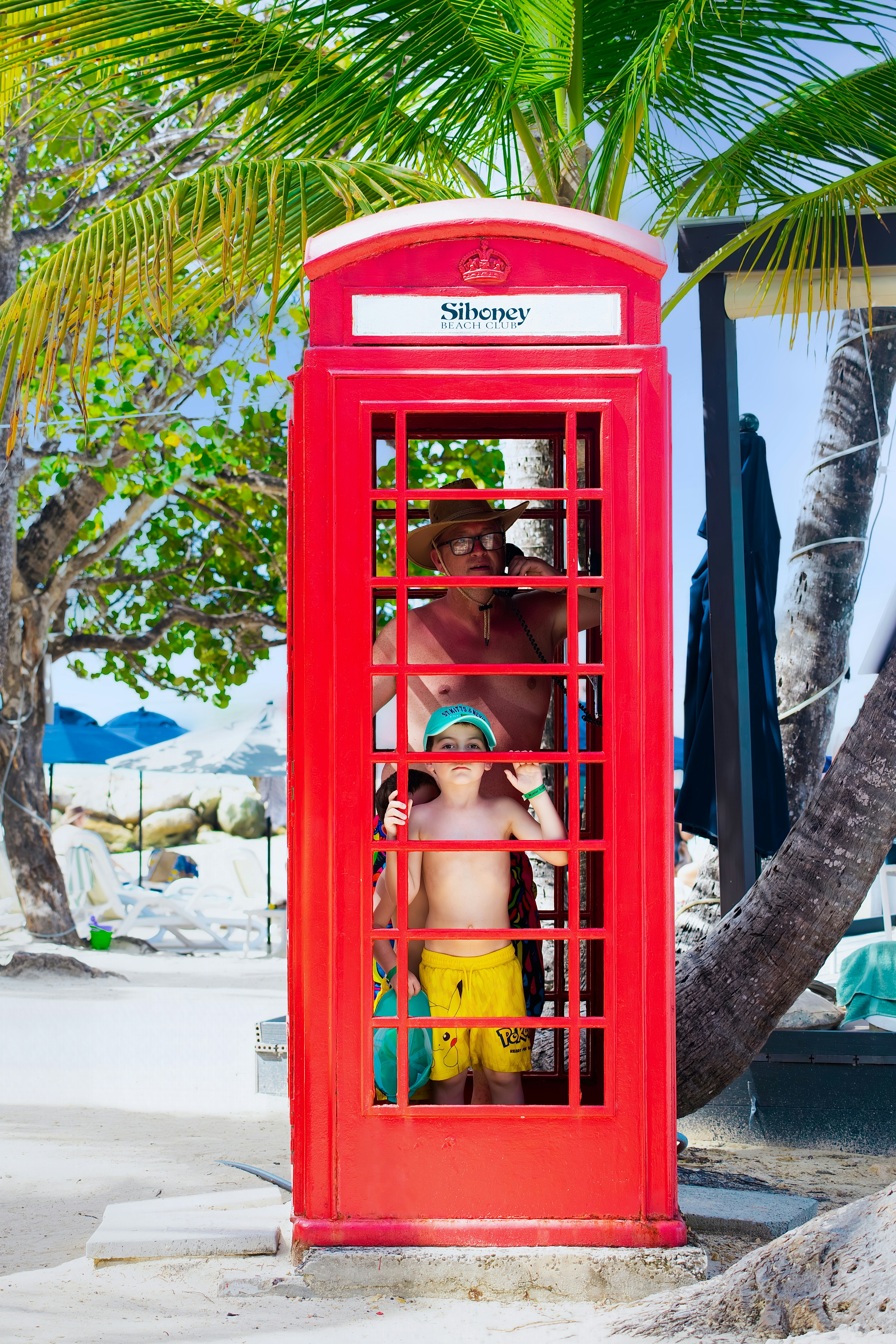 Red Phone Booth on a Sunny Beach: Hidden Moments inside a Classic Frame