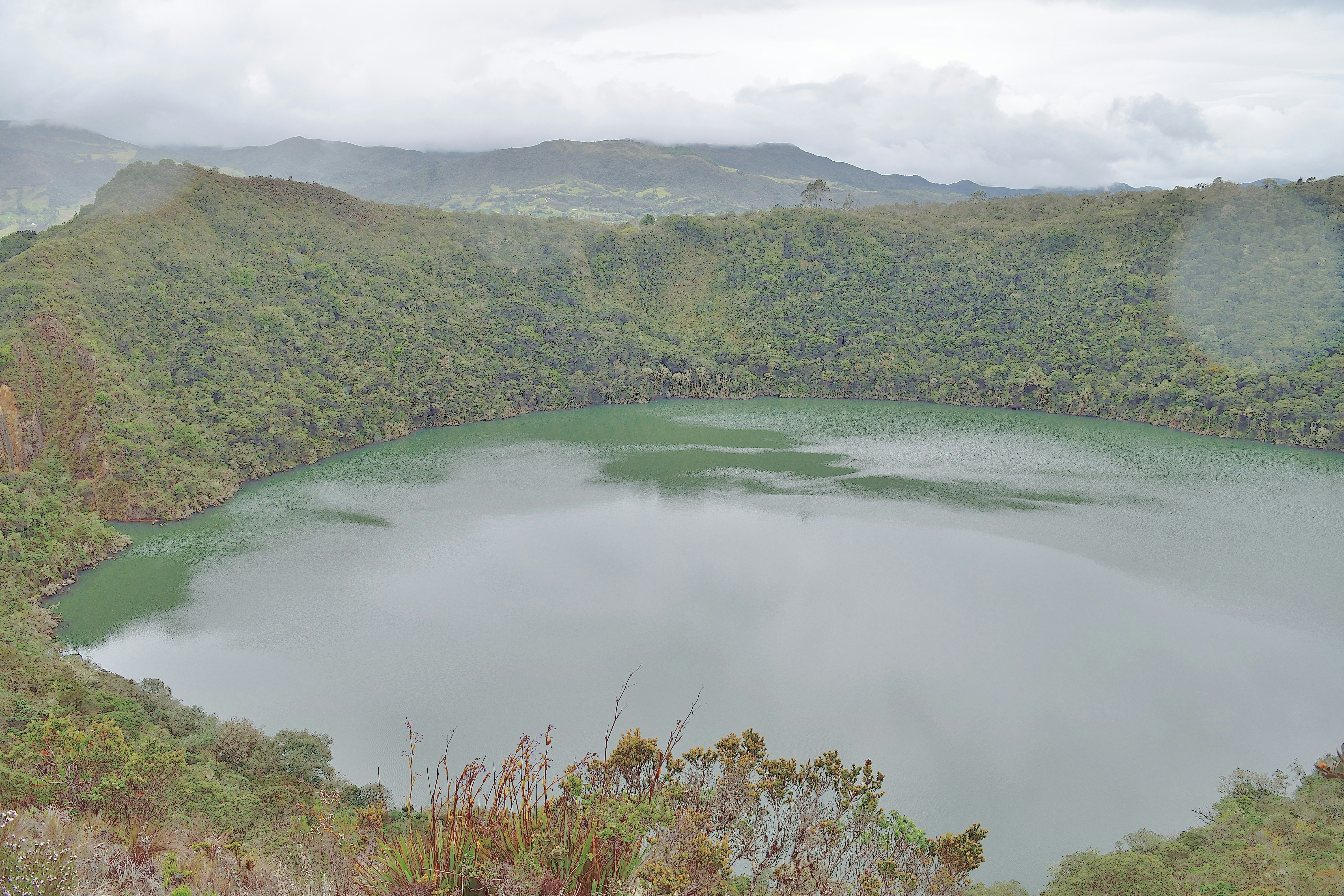 Circular Blue-green Crater Lake Embraced by Verdant Walls