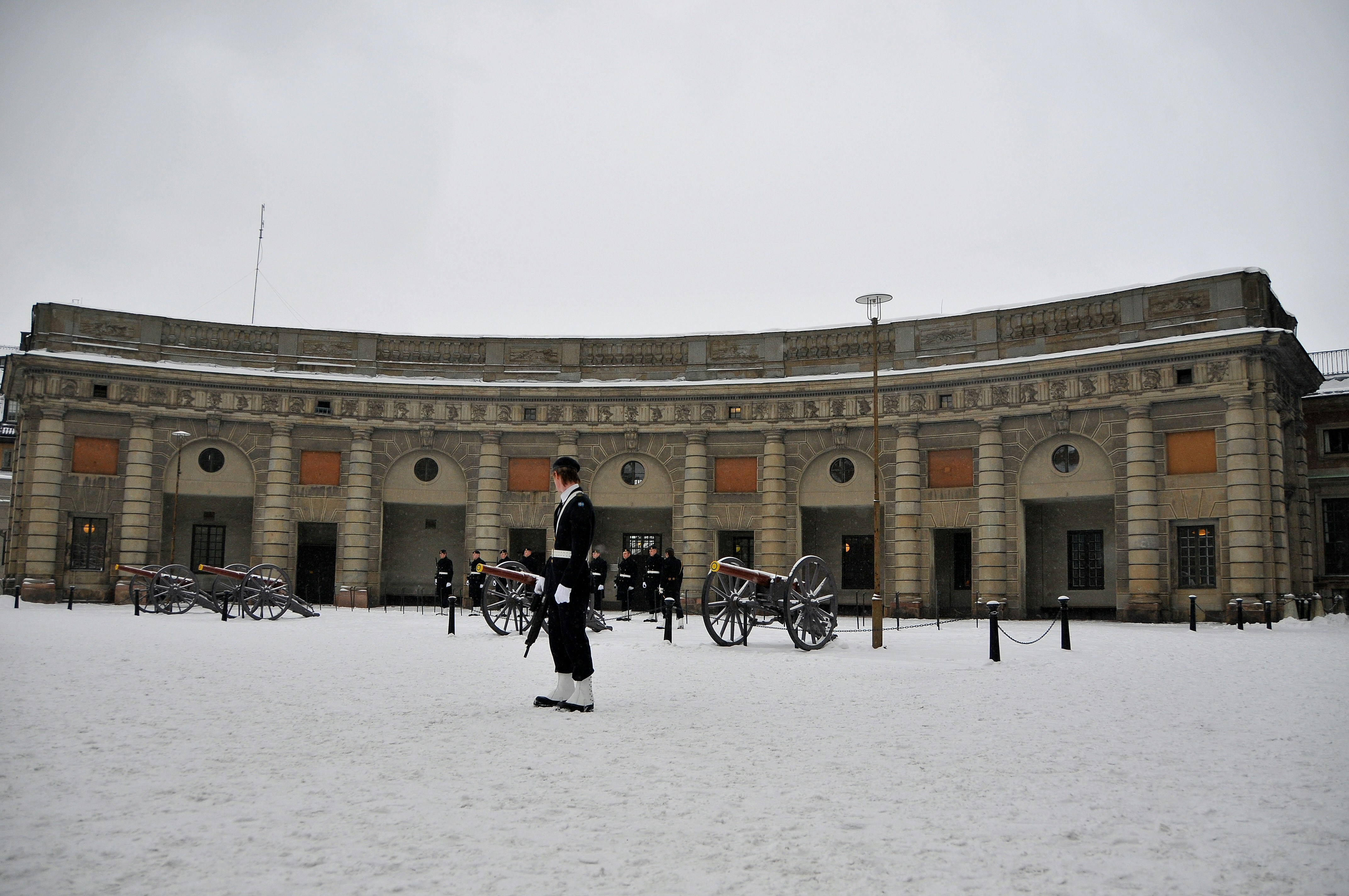 Winter Parade at the Grand Arch: A lone skater in a snow-dusted courtyard