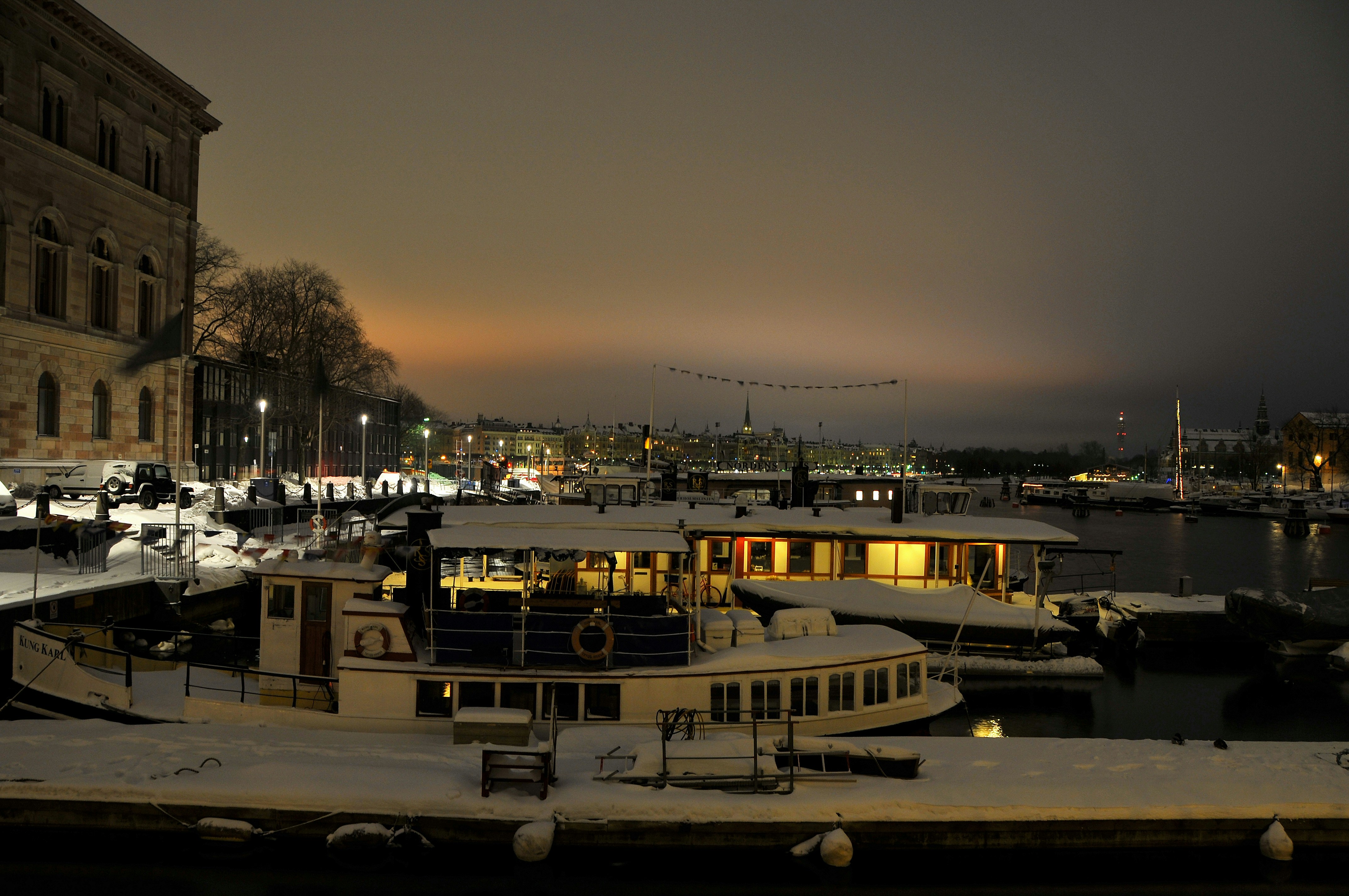 Winter Harbor at Dusk: Boats Rest in Snow under Velvet Sky