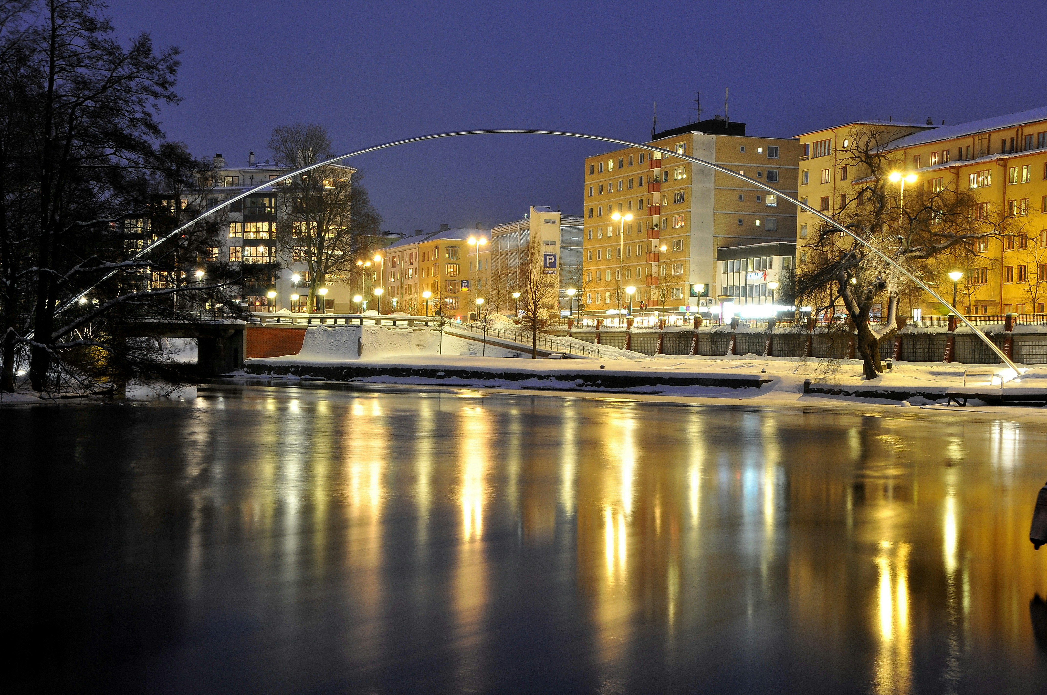 Nighttime Riverside Arc: A Glassy Bridge Between City Lights