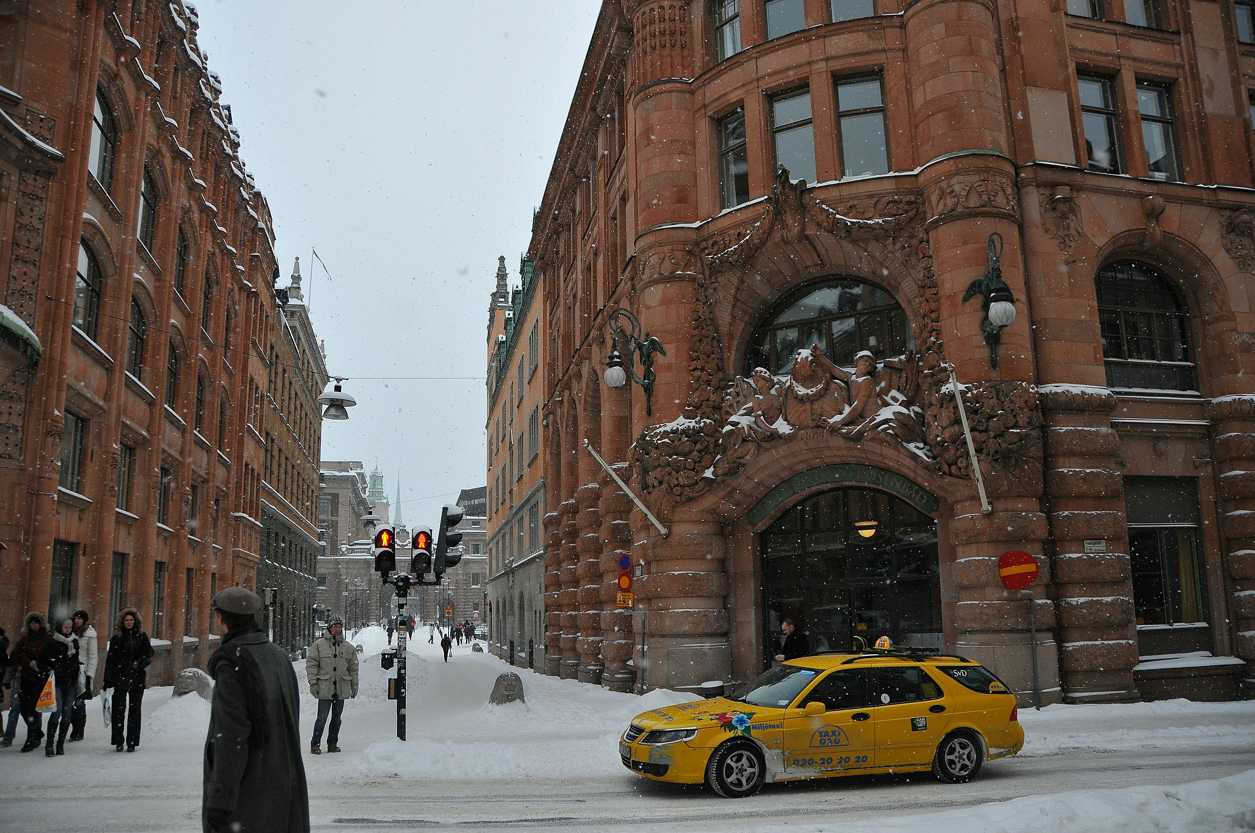 Snowy City Shortcut: Yellow Taxi Beside Winter Brick Arch