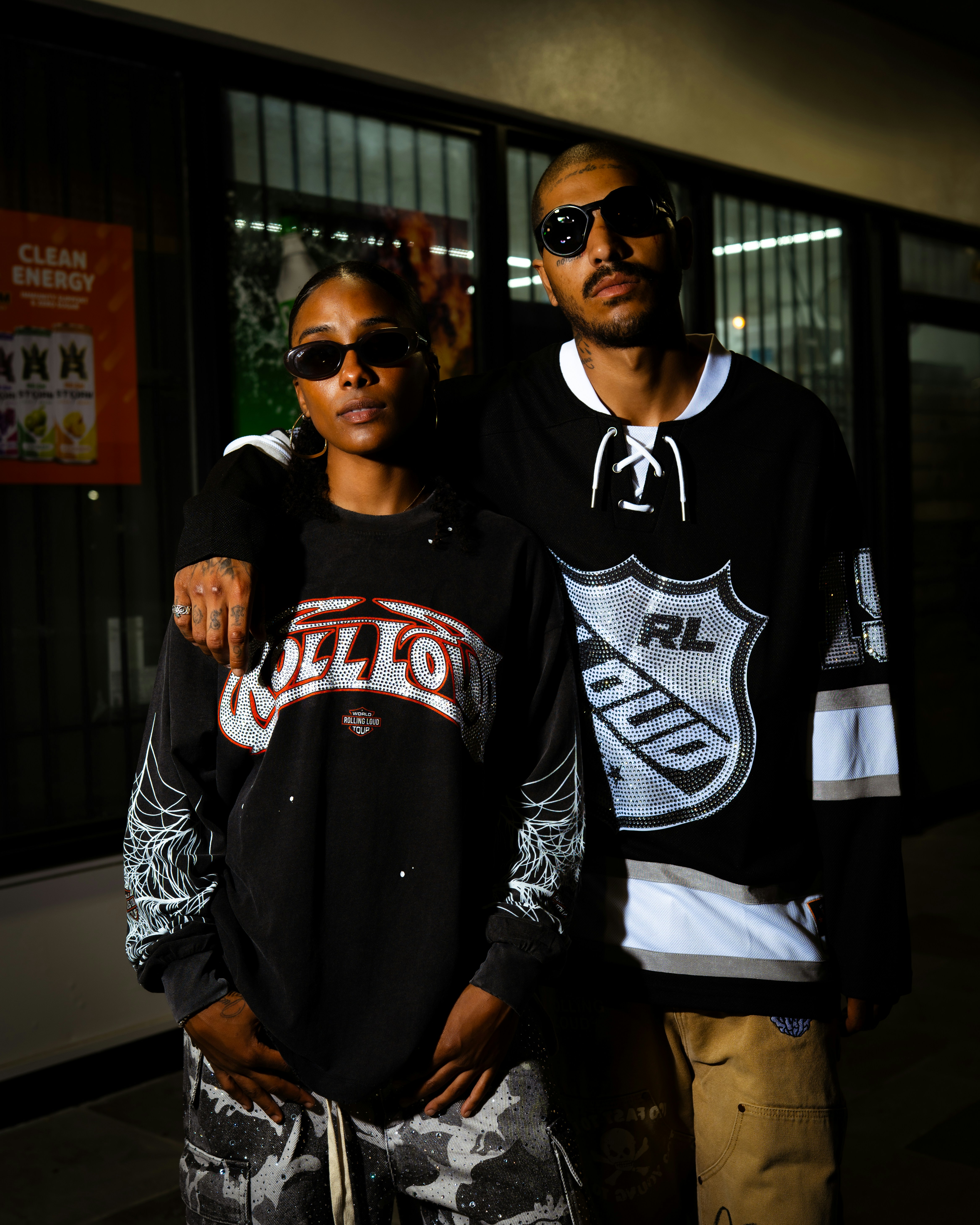 Urban duo in coordinated streetwear under night glow