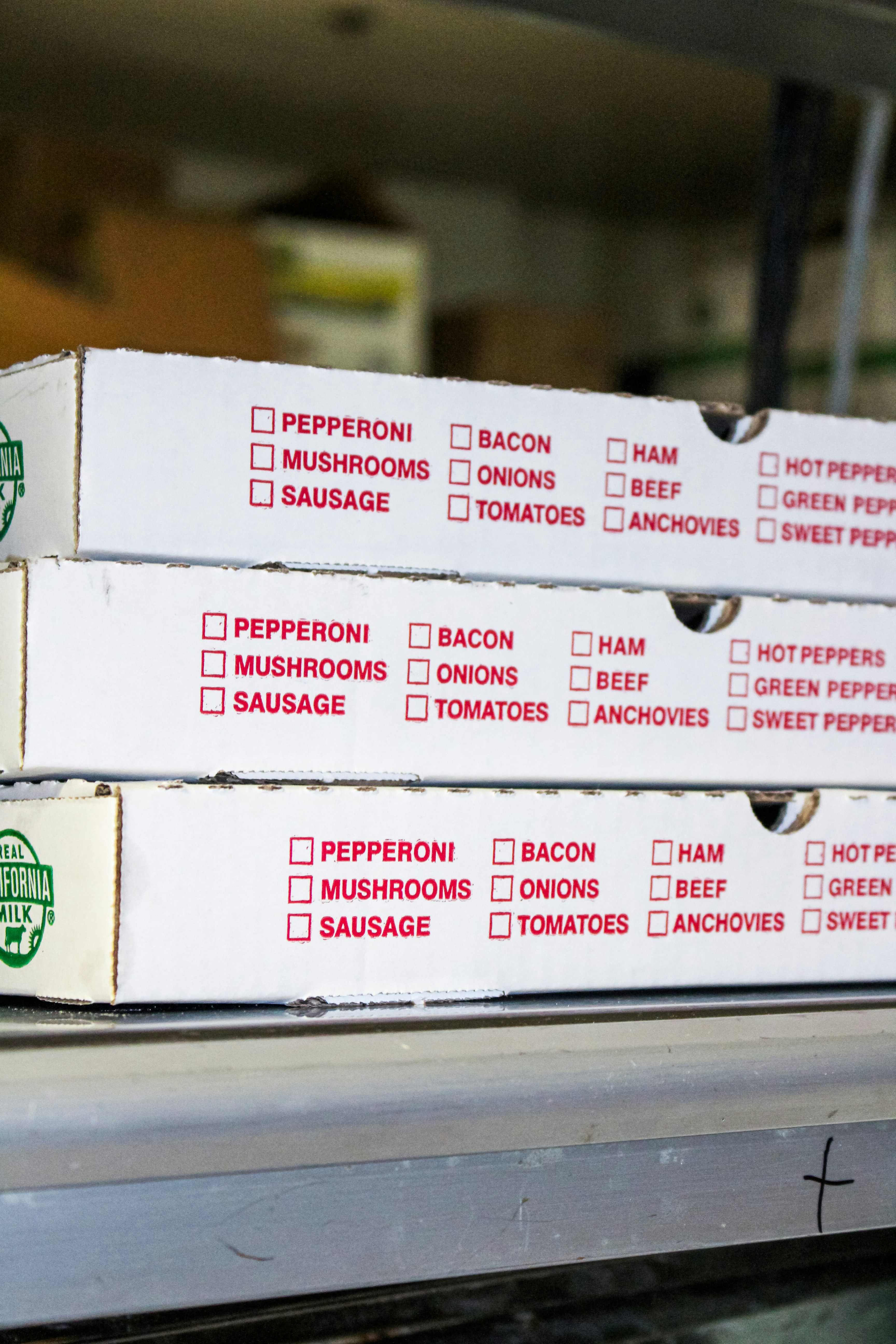 Stacked Pizza Boxes on a Stainless Shelf