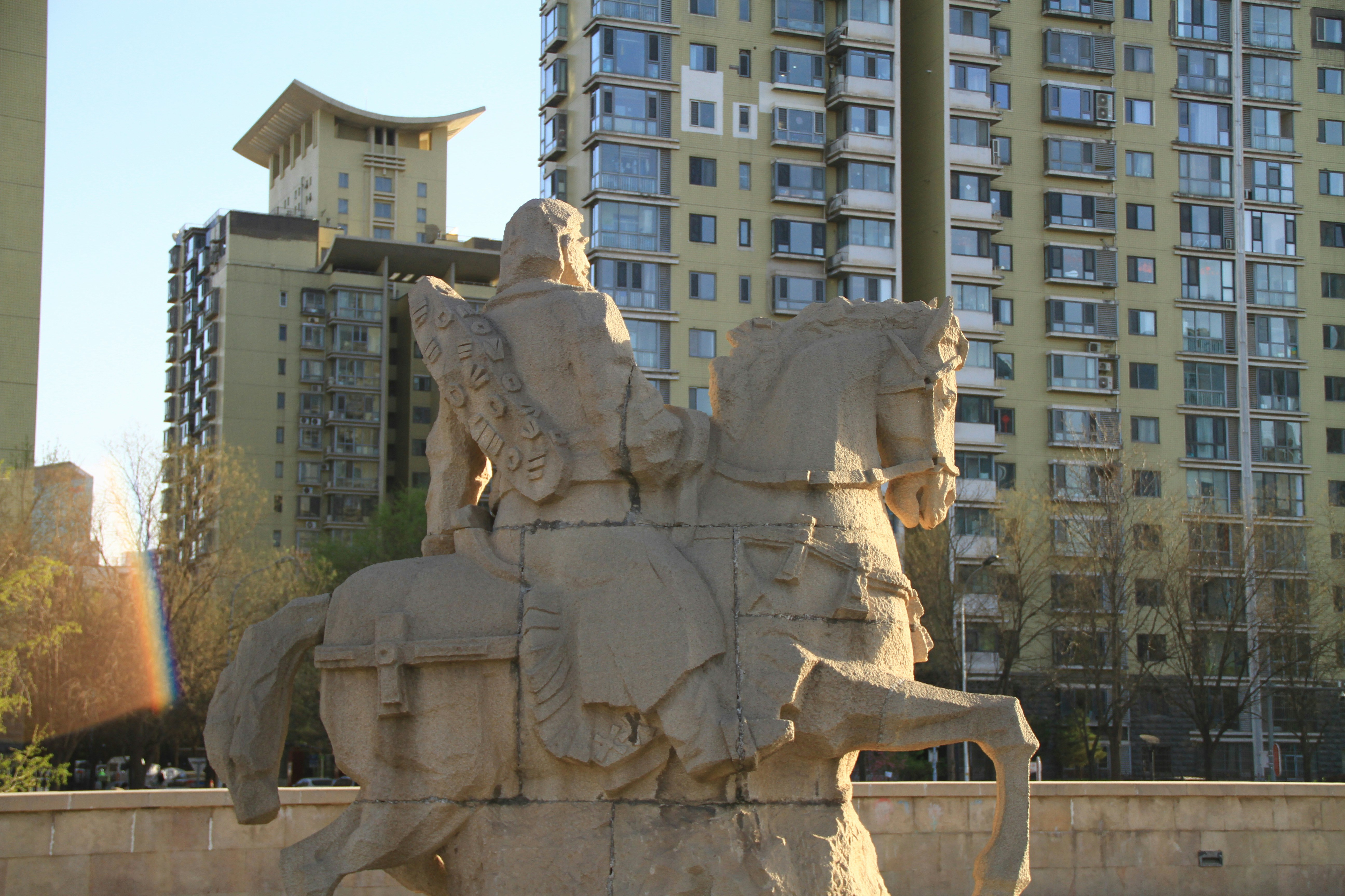 Horse and rider statue under urban towers