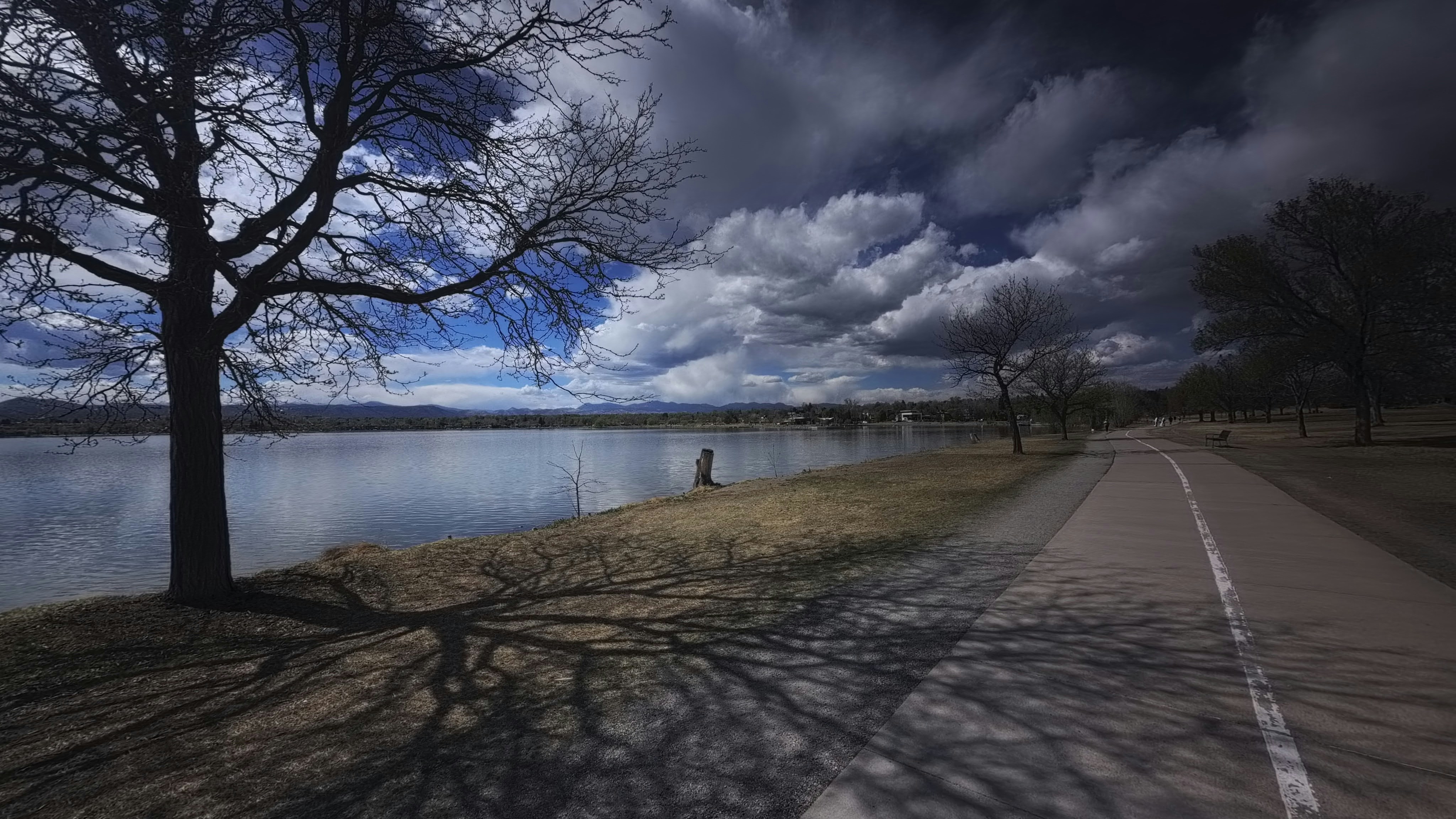 Quiet Lakeside Path Under Brooding Clouds